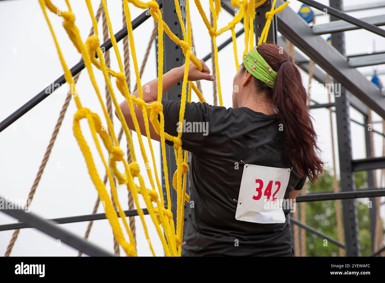 A view of an athlete climbing a rope, seen at an obstacle course ...
