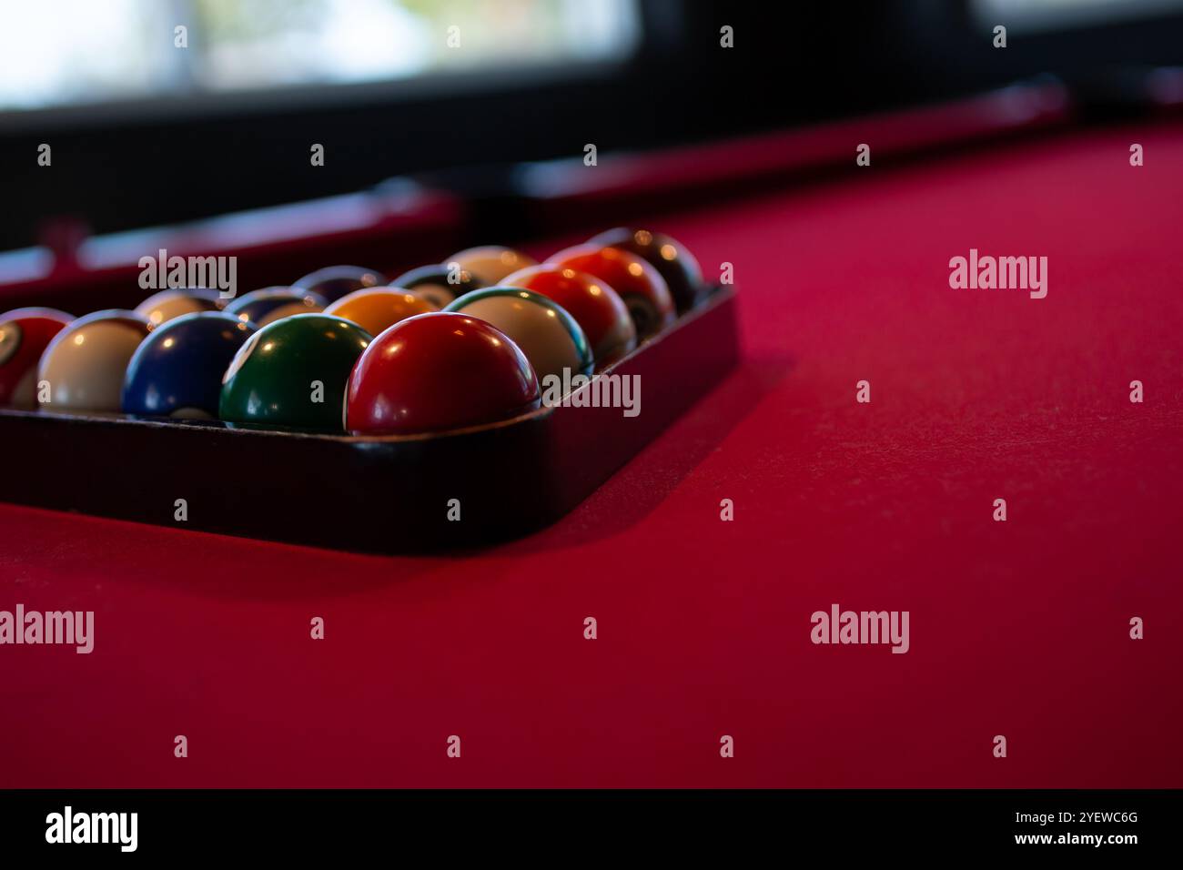 A view of pool balls inside a triangle rack on a red felt pool table ...