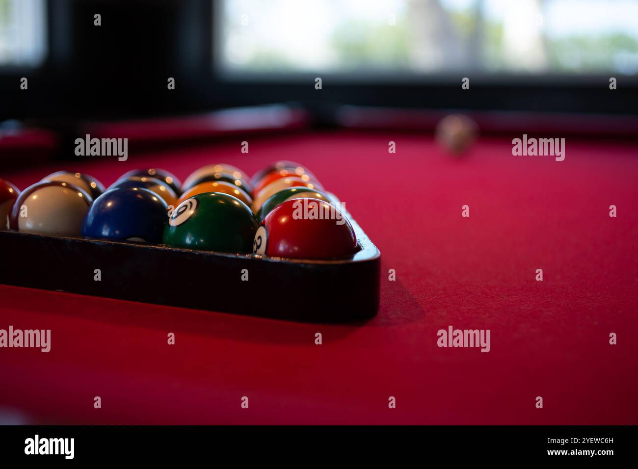 A view of pool balls inside a triangle rack on a red felt pool table ...