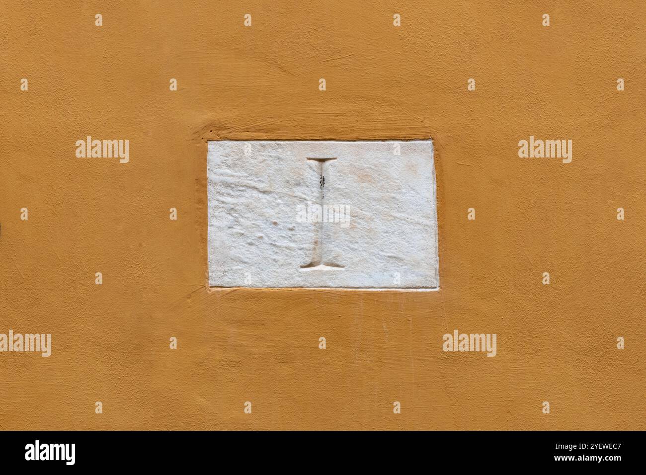 Number one door number carved into panel on plaster wall Stock Photo ...