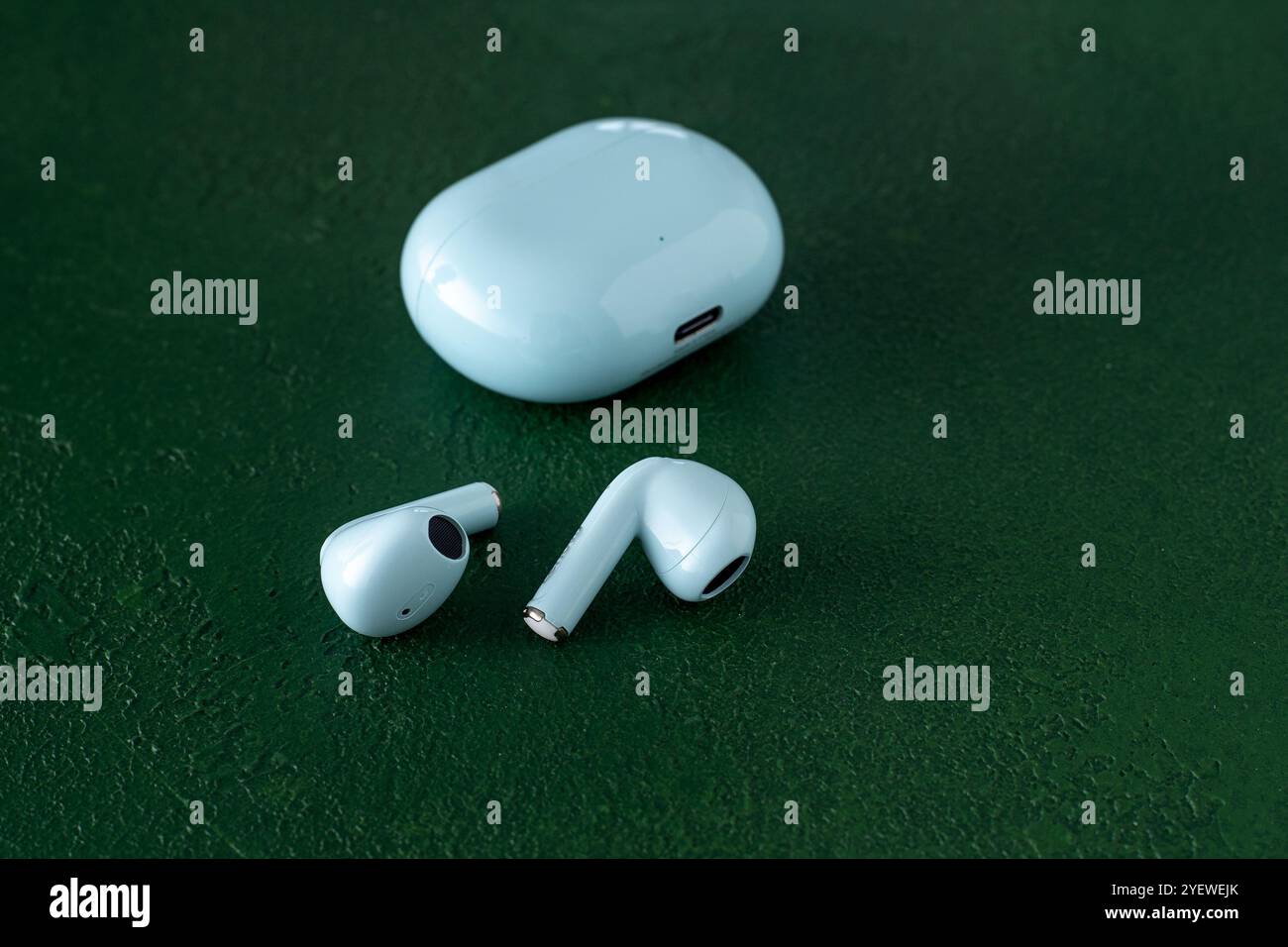 Wireless headphones on green background. Wireless mini headphone in ...