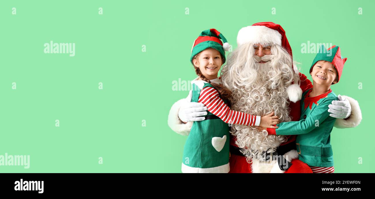 Little elves hugging Santa Claus on green background with space for ...