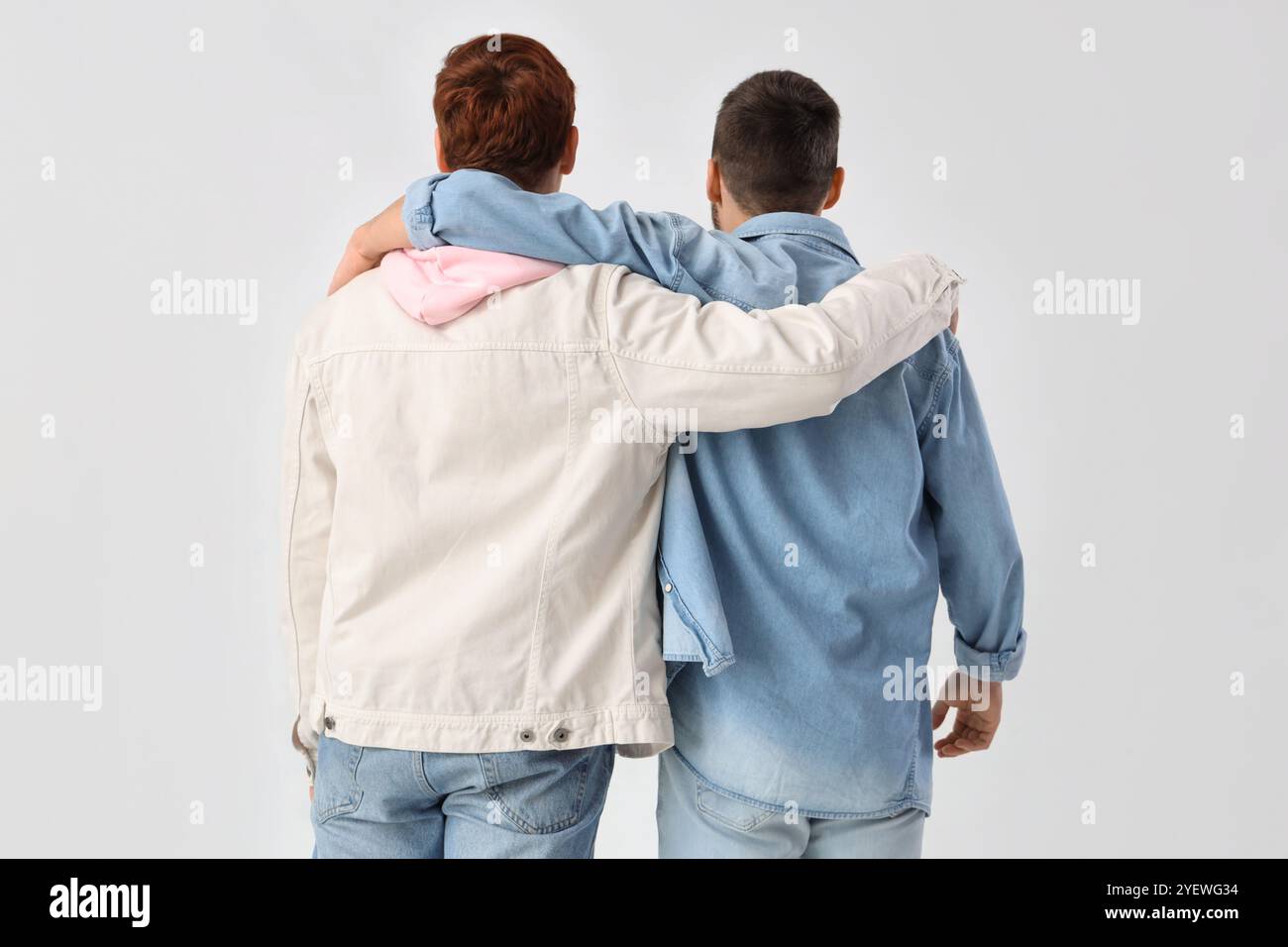 Male friends hugging on white background, back view Stock Photo - Alamy