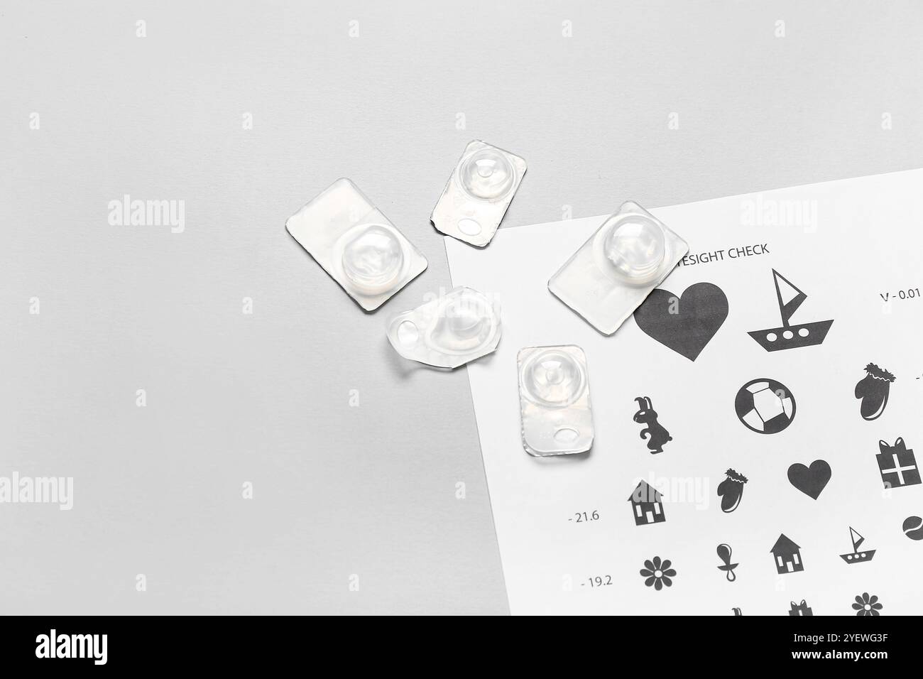 Eye test chart with contact lenses on white background Stock Photo - Alamy