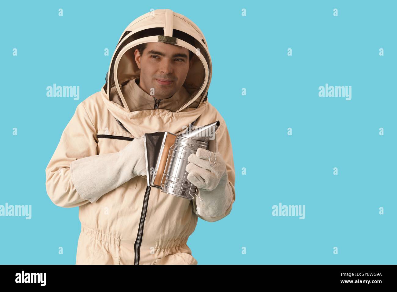 Male beekeeper with smoker on blue background Stock Photo - Alamy