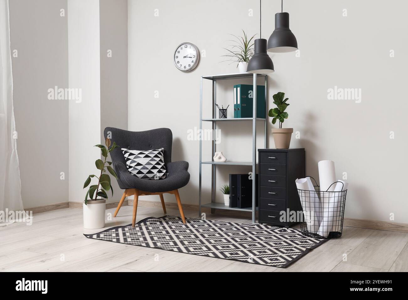 Interior of modern office with armchair, chest of drawers and shelving ...