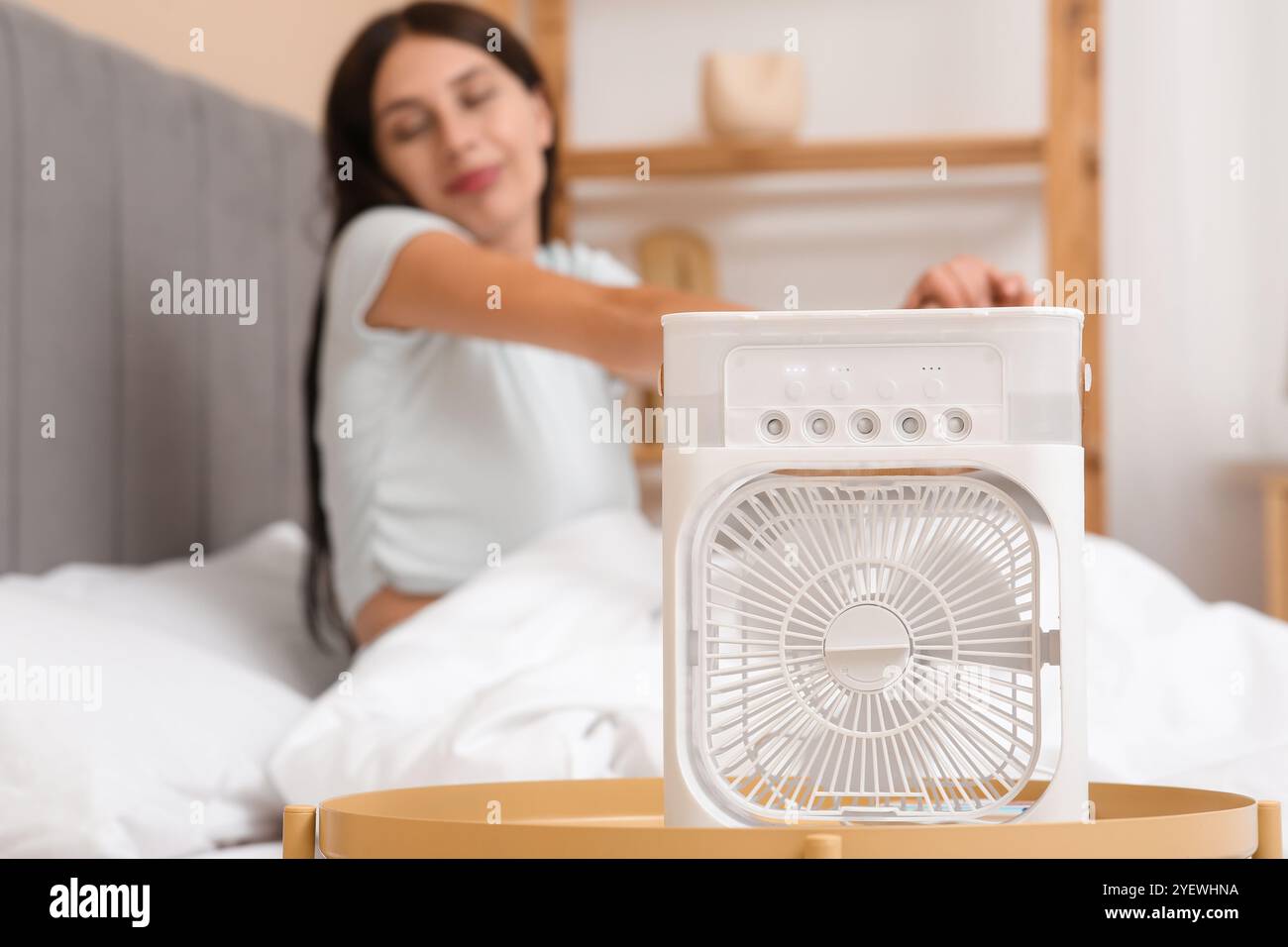 Portable table fan with humidifier and beautiful young woman in bedroom ...