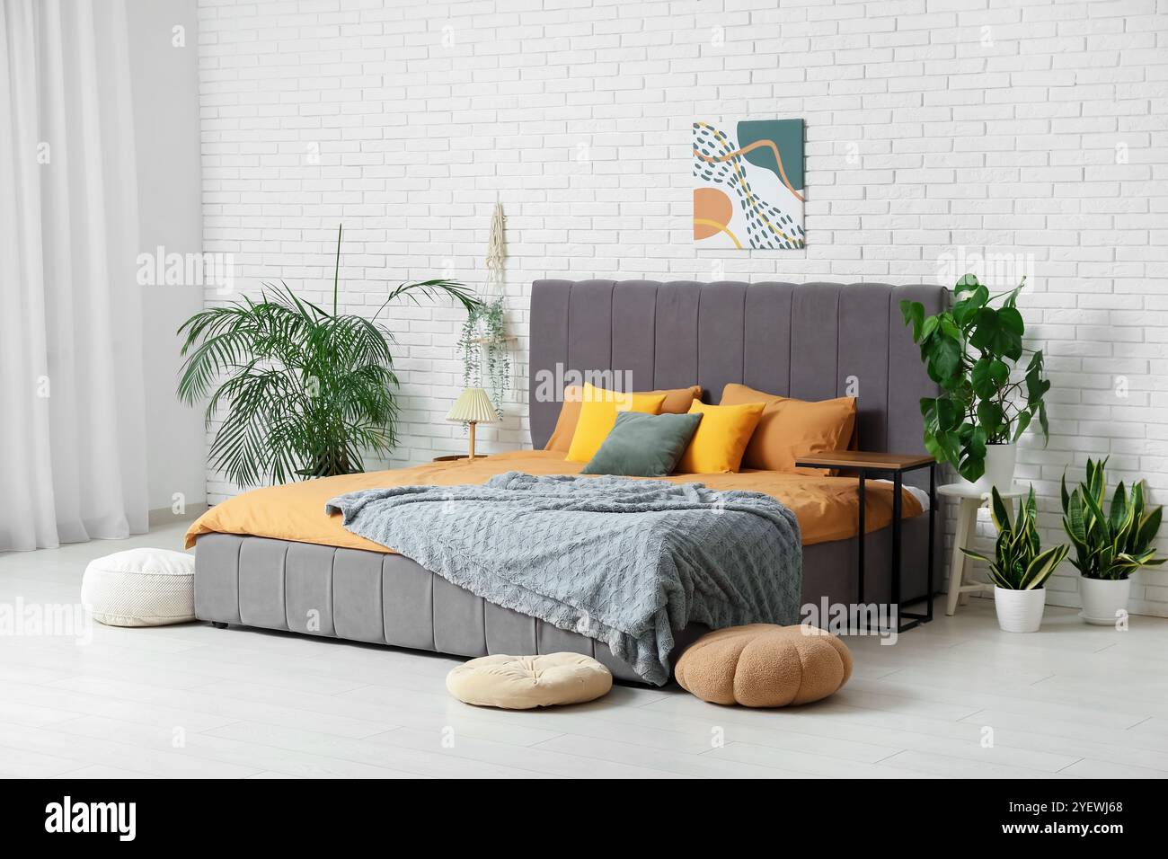 Interior of comfortable bedroom with bed, houseplants and bedside ...
