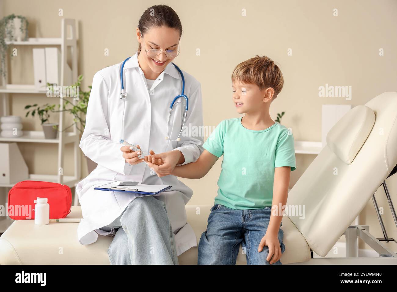 Little diabetic boy with doctor using lancet pen in clinic Stock Photo ...