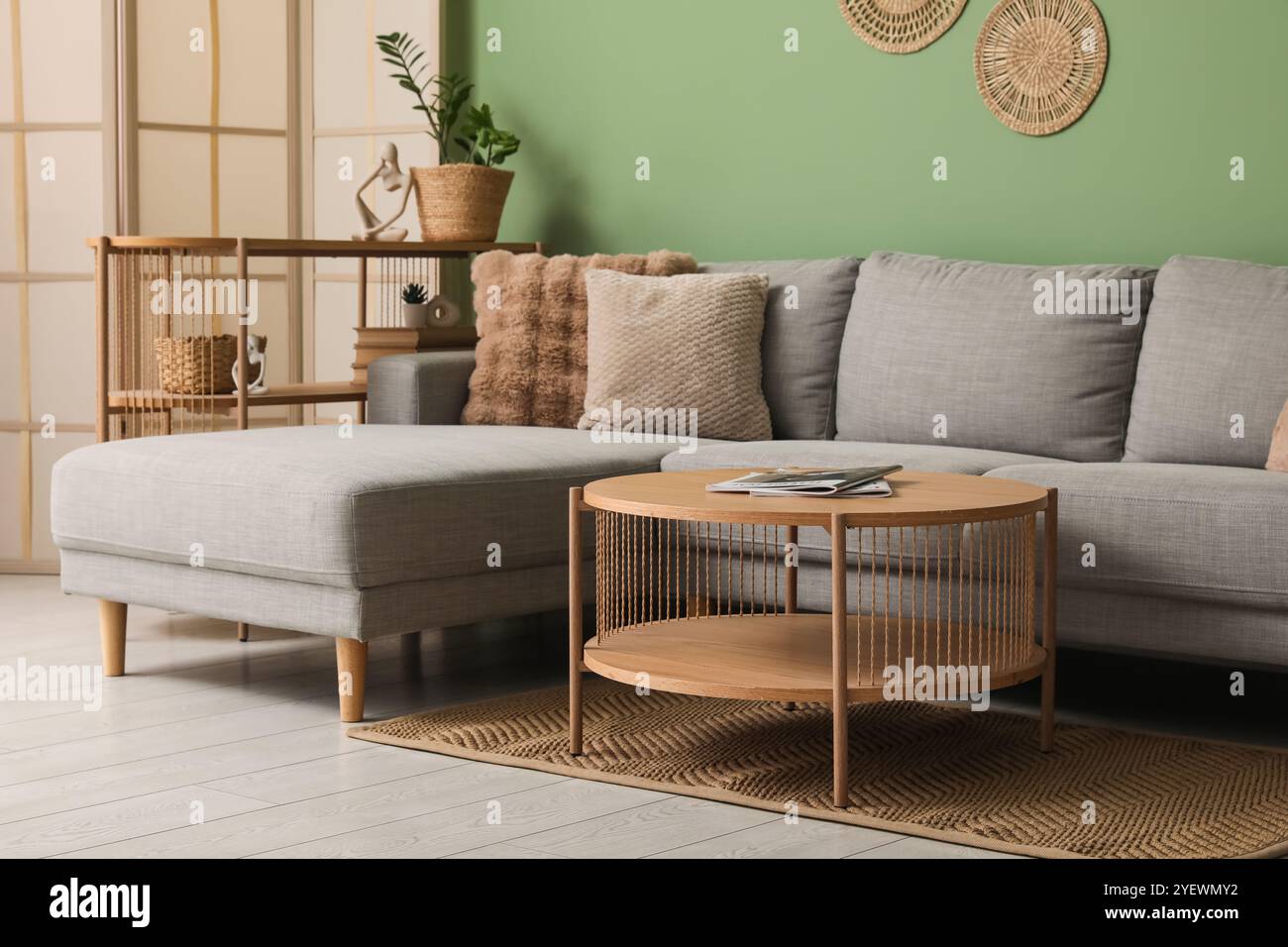 Comfortable sofa, coffee table and shelving unit in interior of living ...
