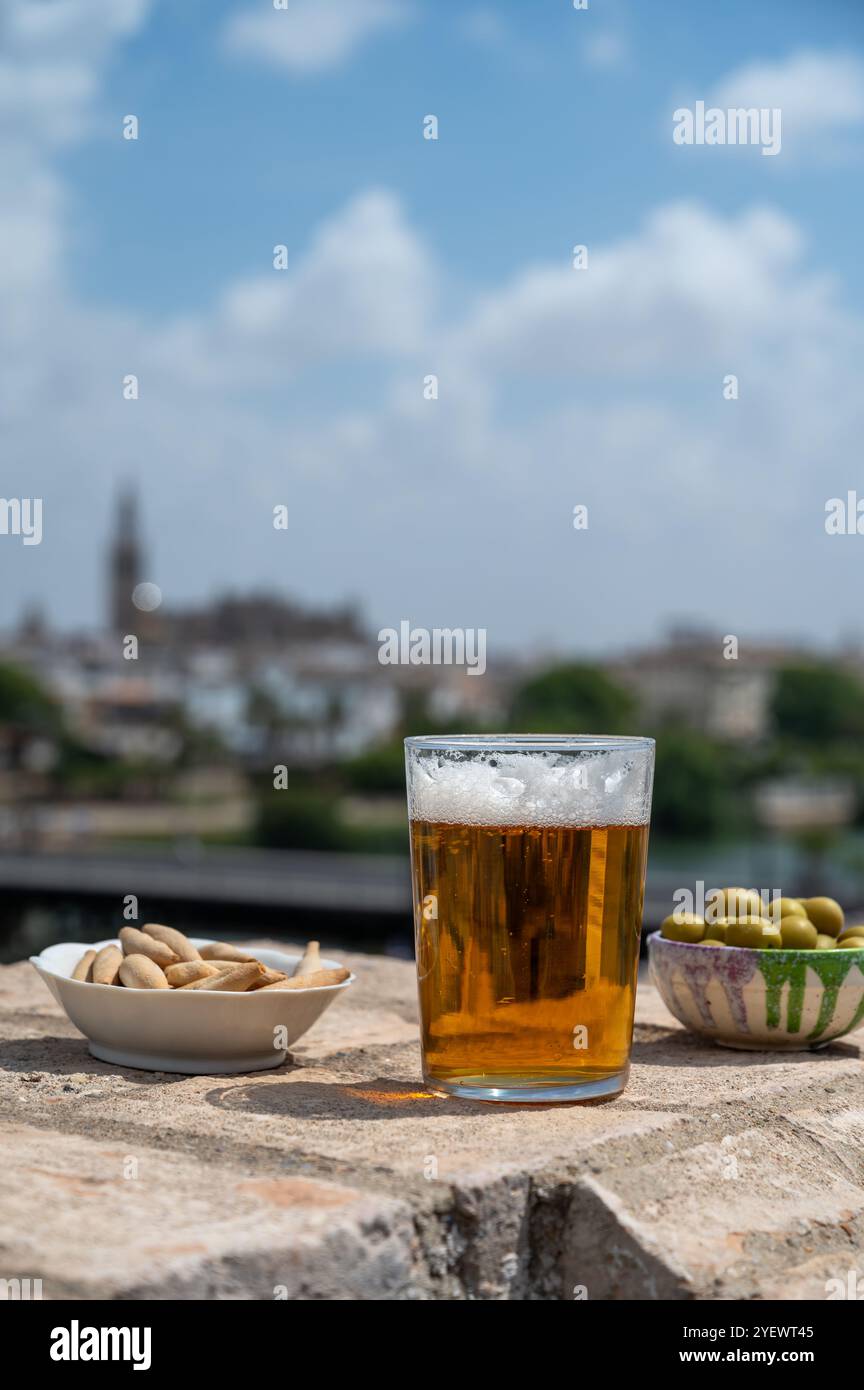 Spanish lager beer in glasses and bowl with green andalusian olives ...