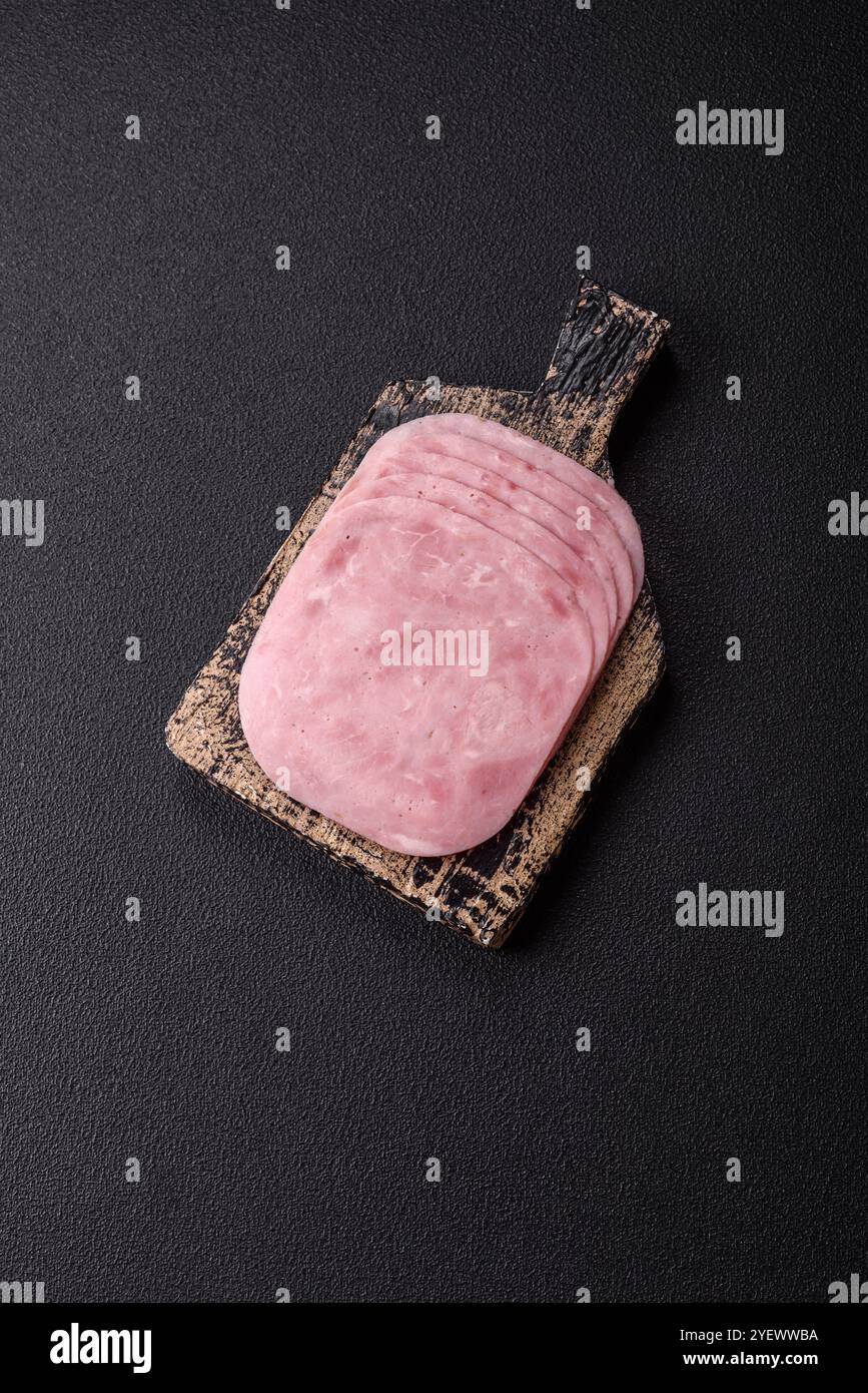 Ham, spam with salt, spices and herbs cut into slices on a dark ...