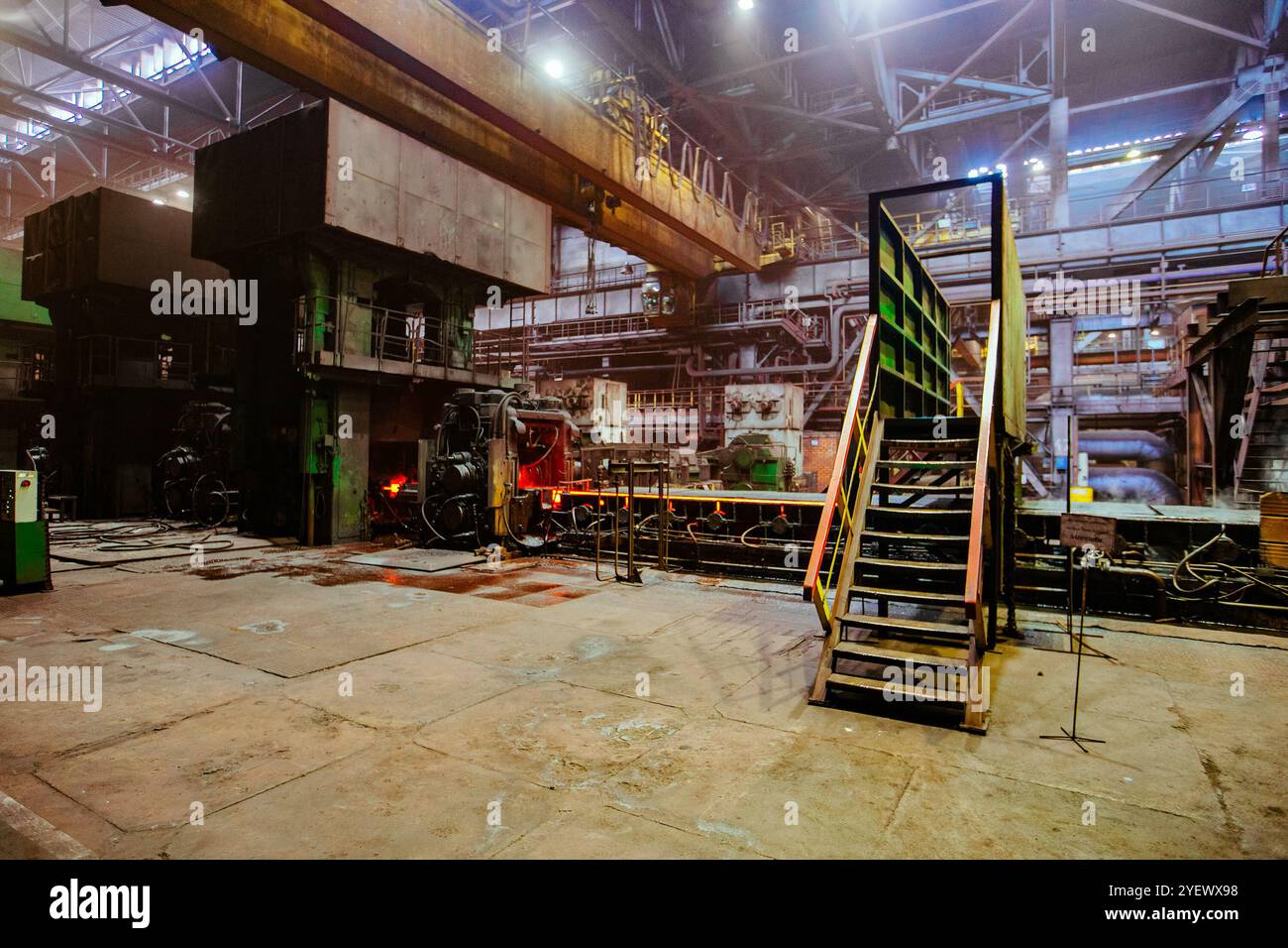 Rolled metal factory hot steel bar on conveyor moving through rollers ...