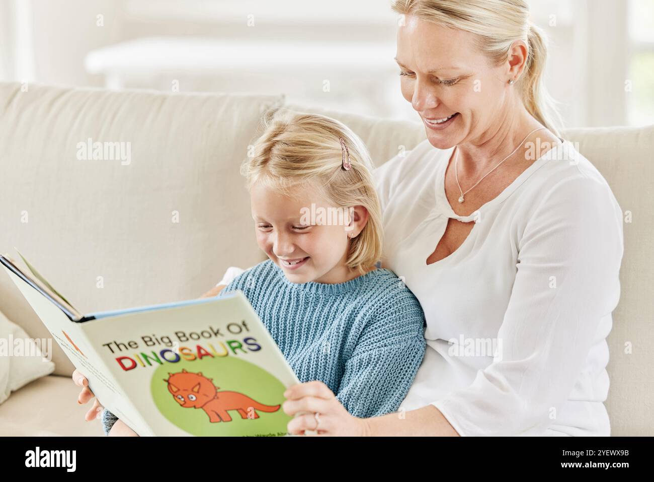 Teaching, happy girl and mother reading book on couch for learning ...
