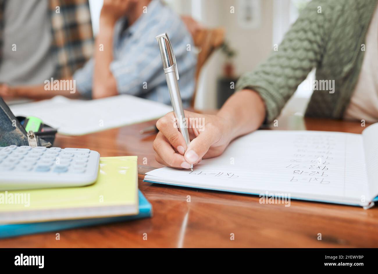 Math book, student and hands with homework on kitchen table for ...