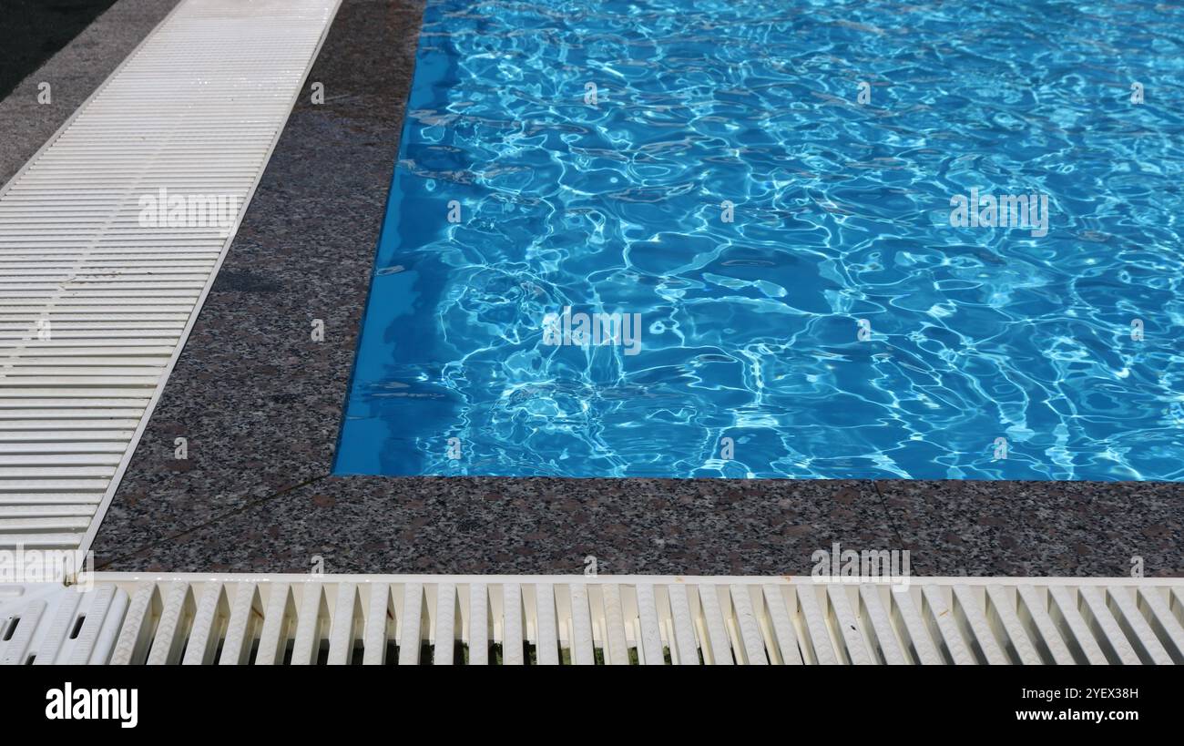 corner part of outdoor swimming pool with blue bright water with small ...