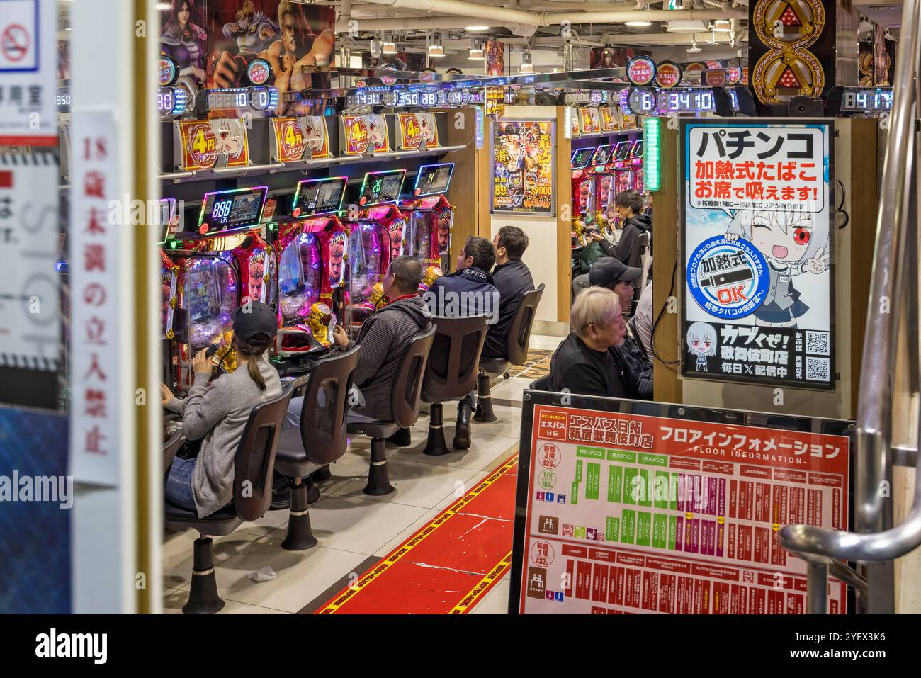 Men gambling on Pachinko machines in Pachinko arcade at night in Tokyo ...
