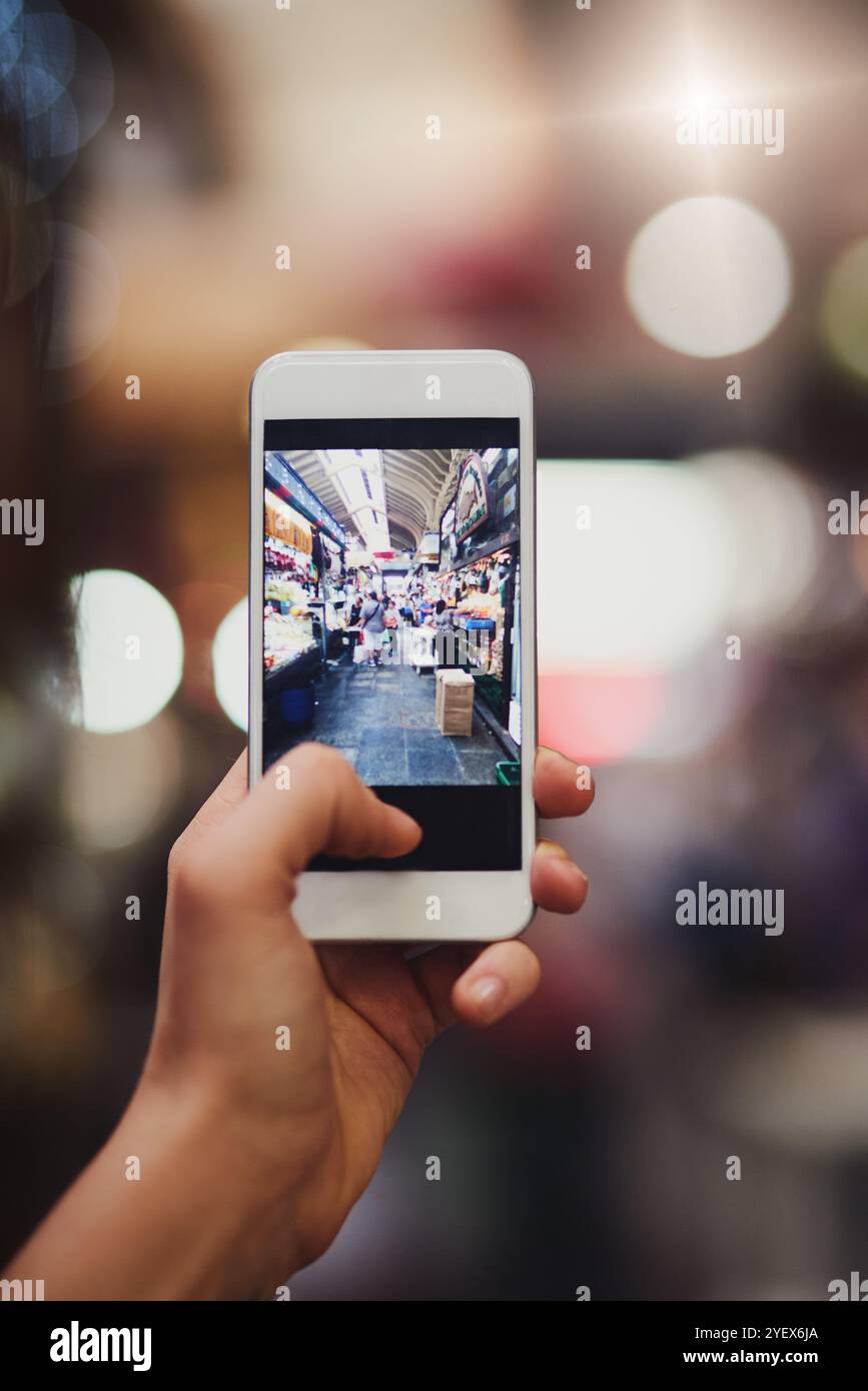 Phone, screen and hands of person take picture in city for night market ...