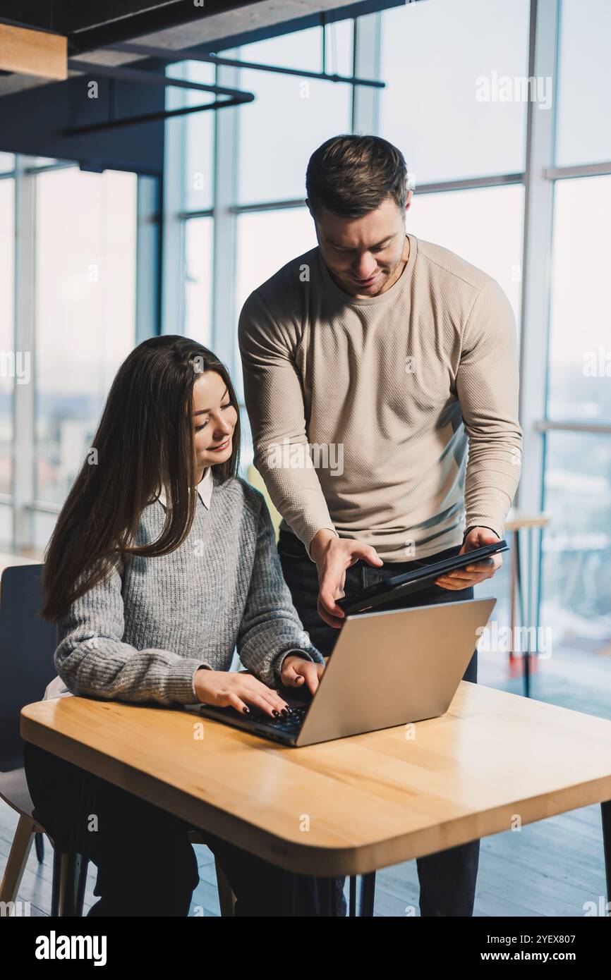 Colleagues share their experience working in the office at a laptop ...