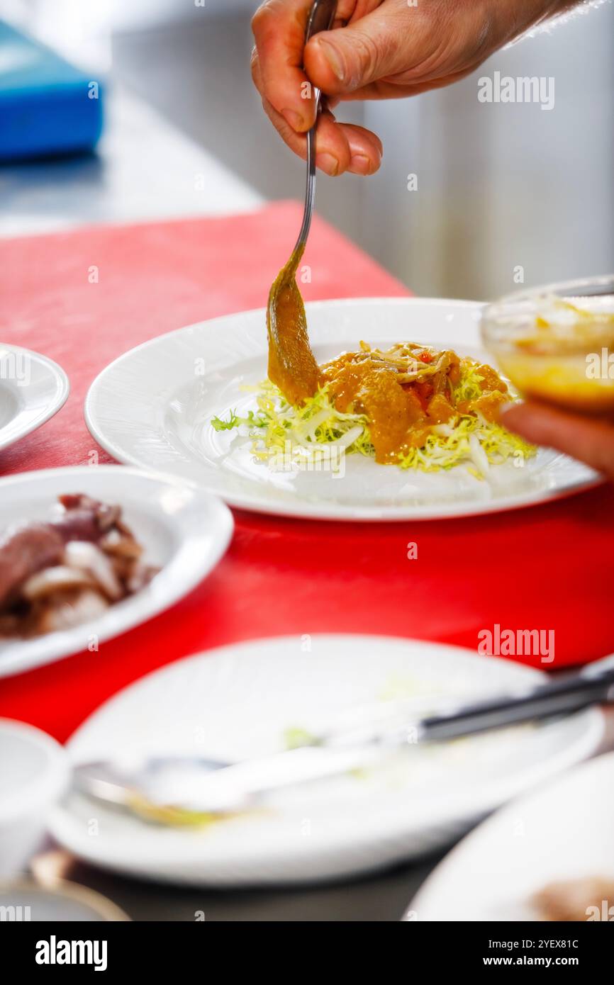 Chef is placing some sauce over a salad Stock Photo - Alamy