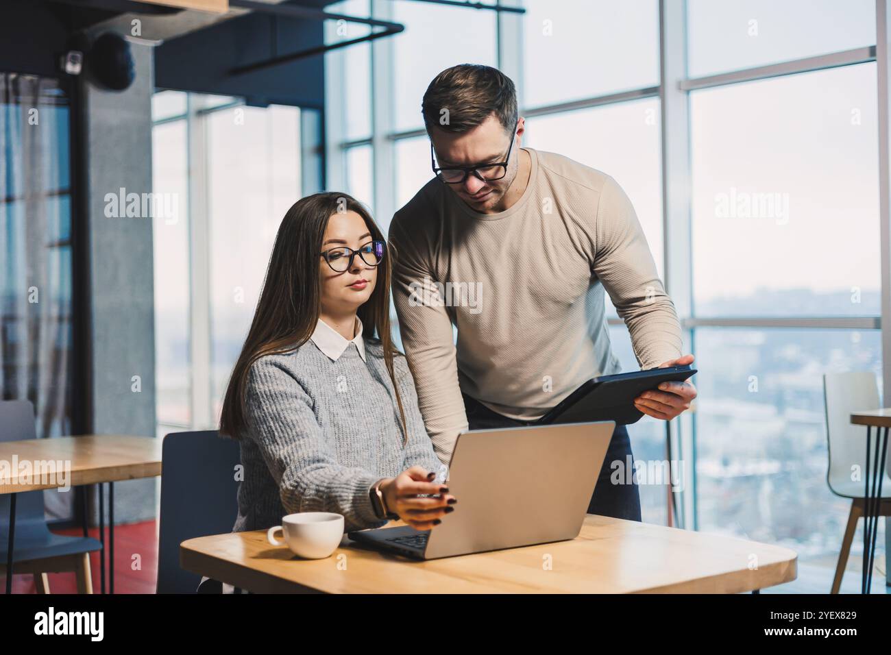 Colleagues share their experience working in the office at a laptop ...
