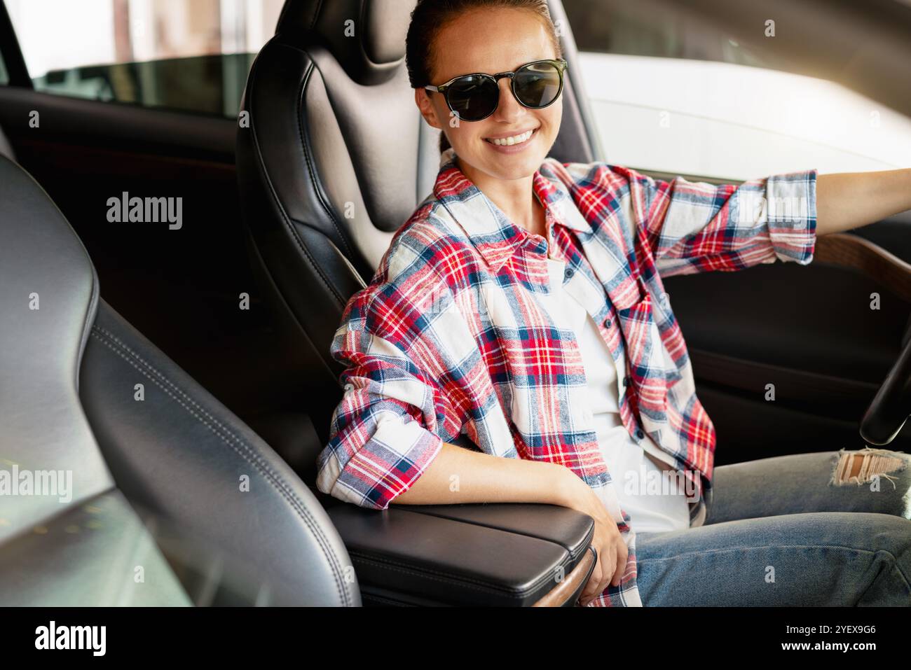 Portrait ow woman in sunglasses in her new car. Car dealership ...