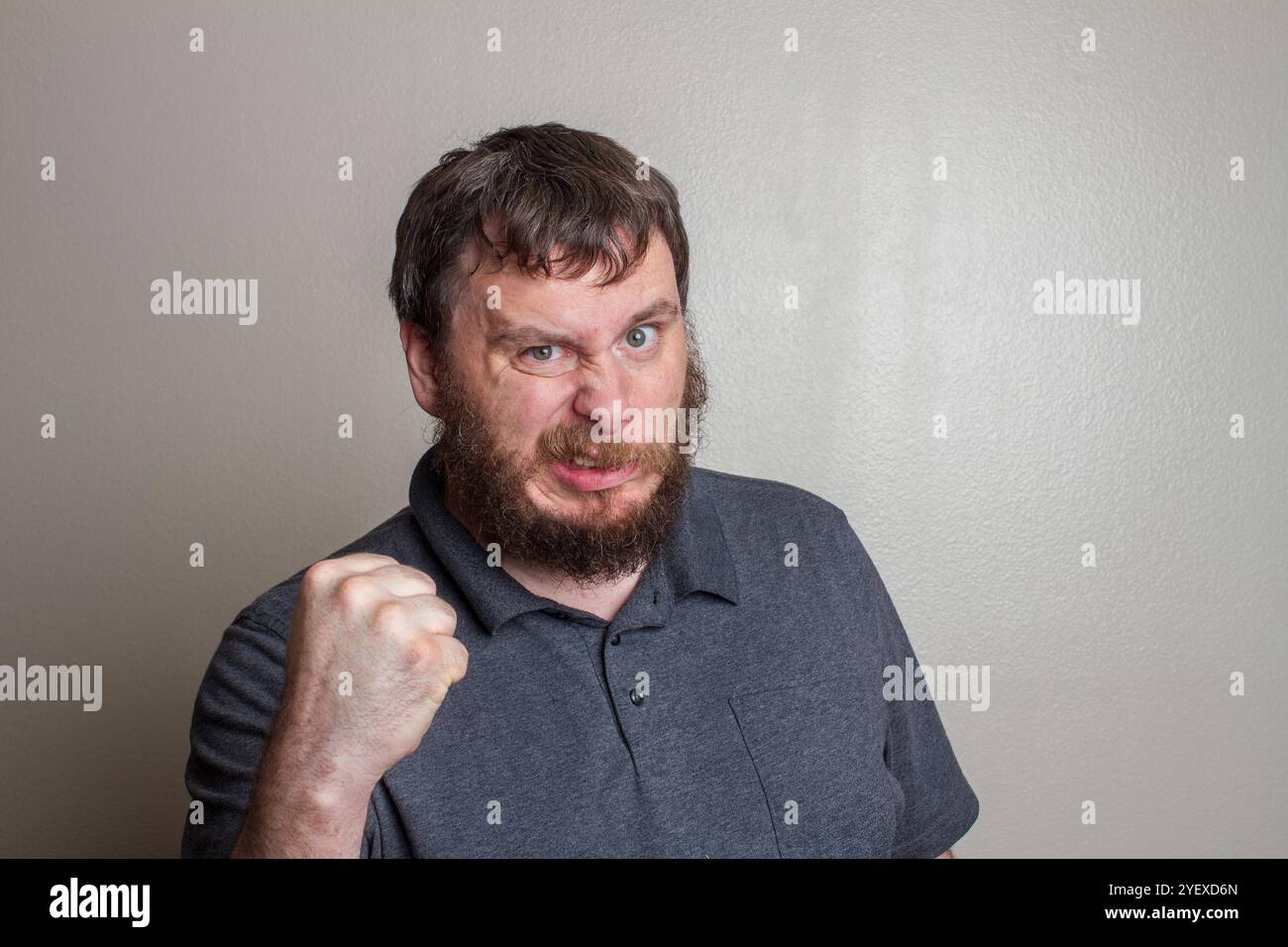 Angry Bearded Man Clenching Fist in Frustration Stock Photo - Alamy