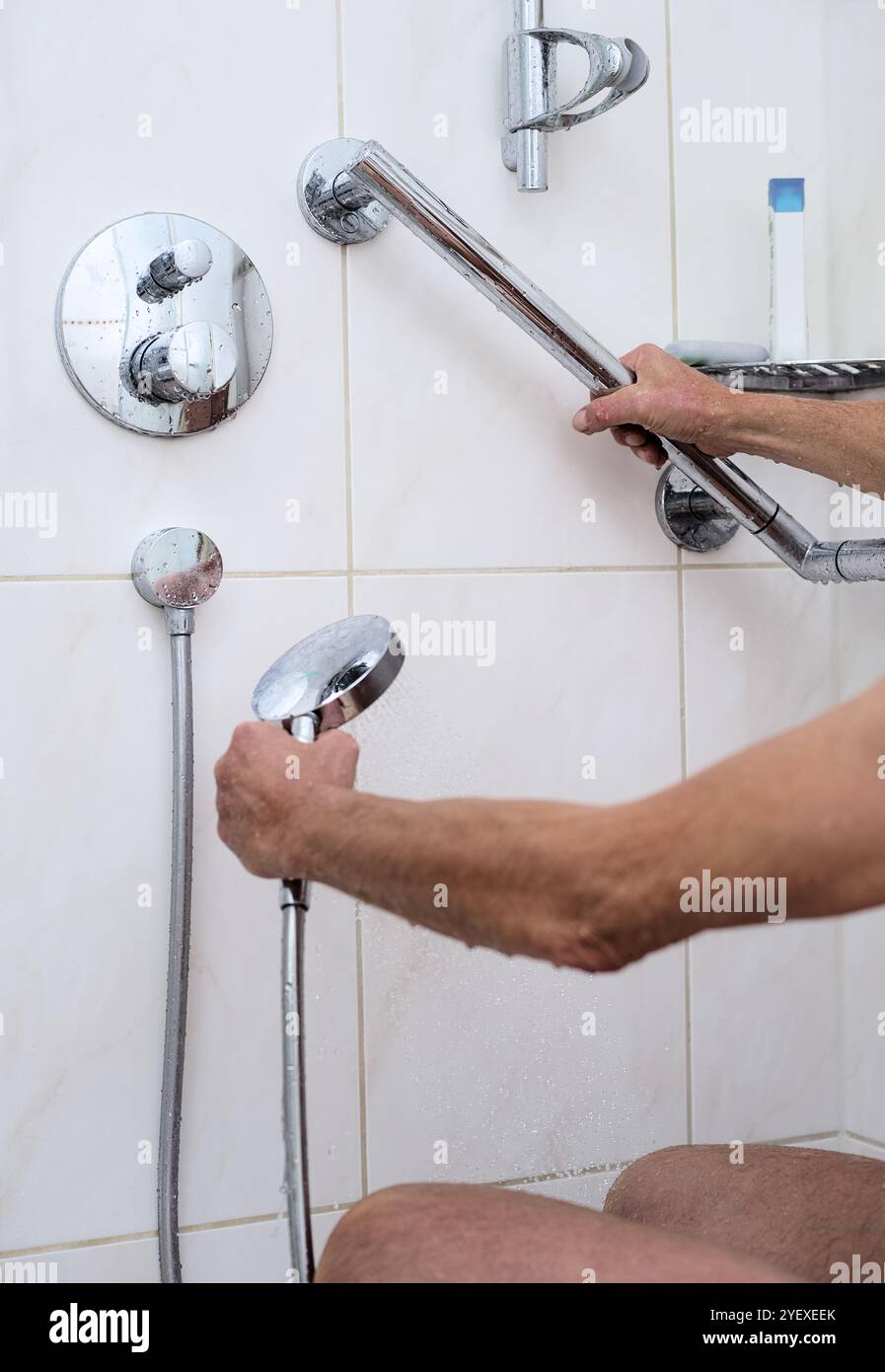 Elderly disabled senior person showering on shower seat with grabrail ...