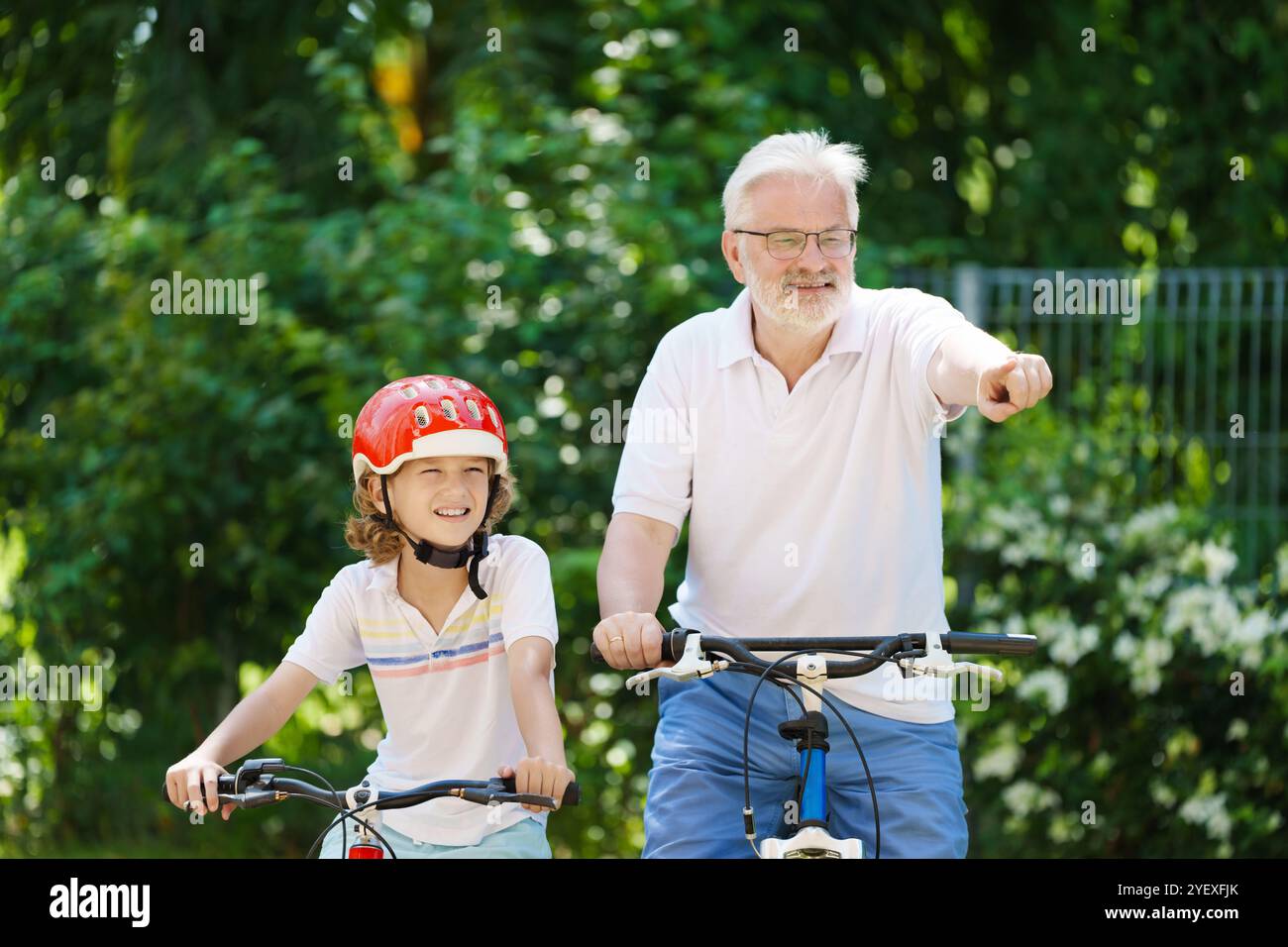 Grandfather and kids in sunny garden. Happy family riding bike in ...