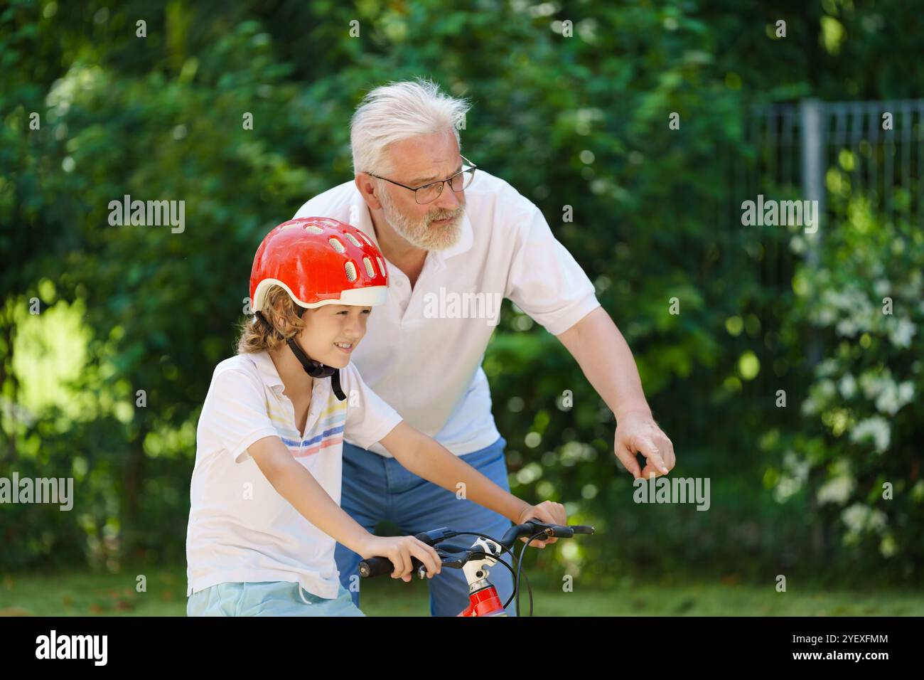 Grandfather and kids in sunny garden. Happy family riding bike in ...