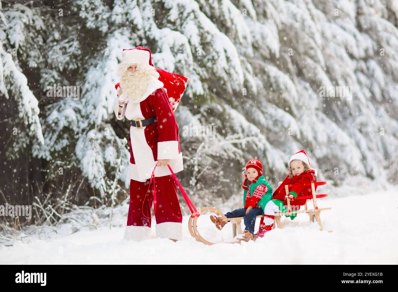 Kids and Santa with Christmas gifts in snowy forest. Children help ...