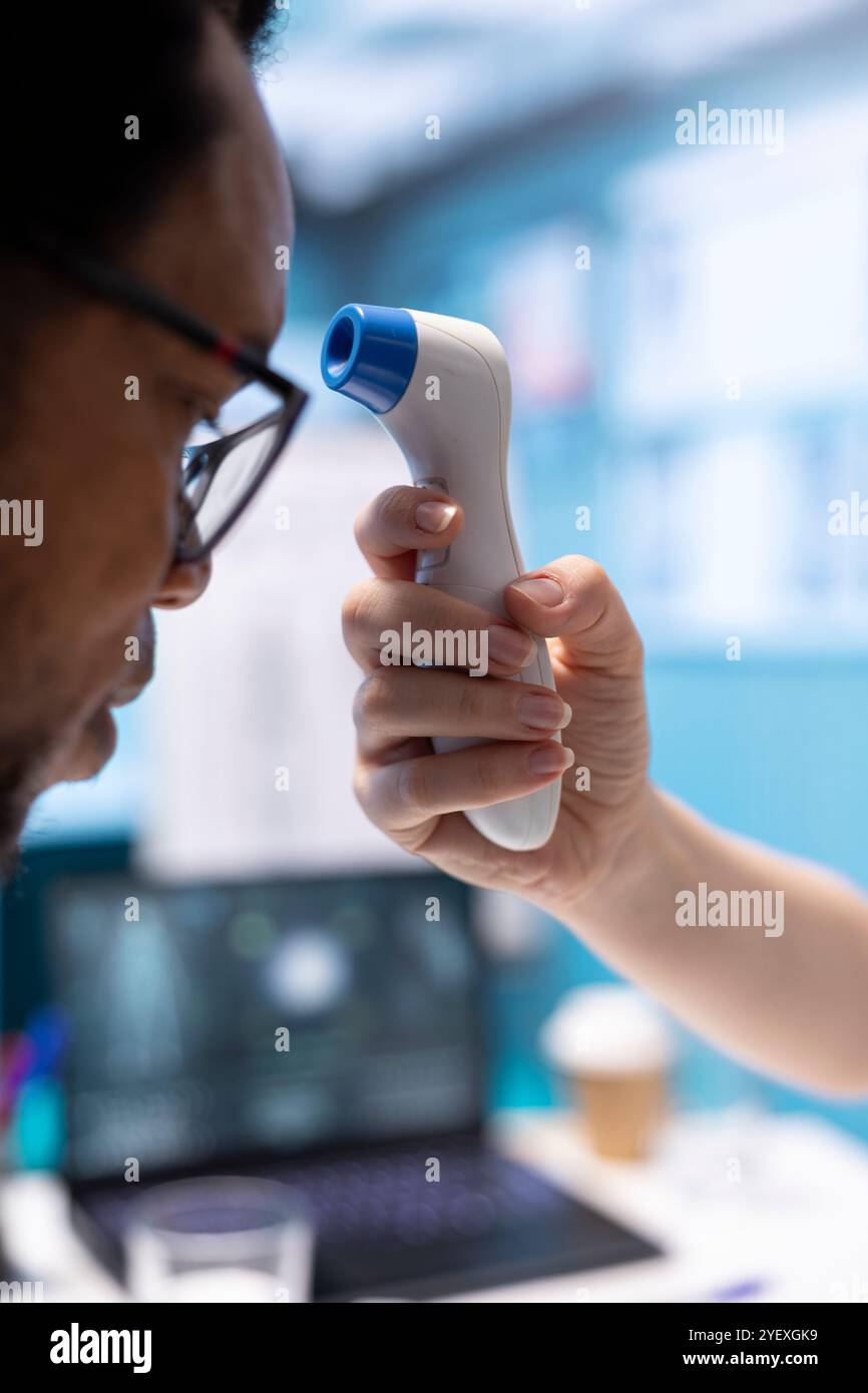 Healthcare specialist using thermometer to check fever measurements ...