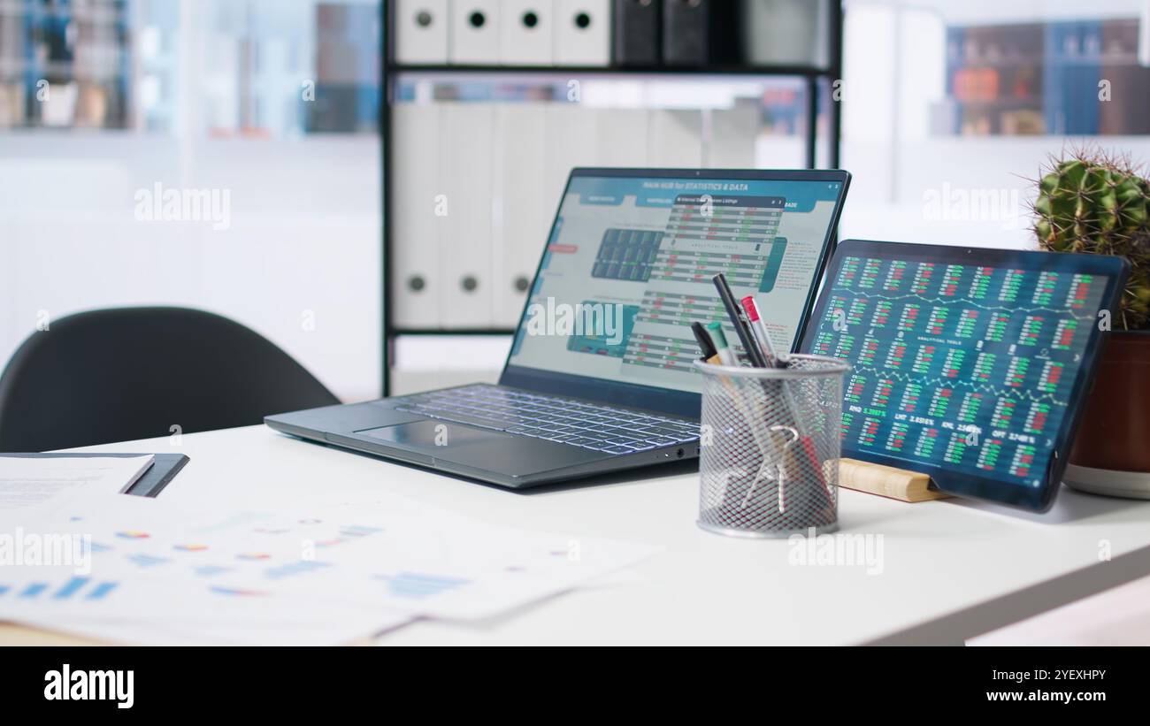 Stock market values going up and down on laptop in empty financial ...