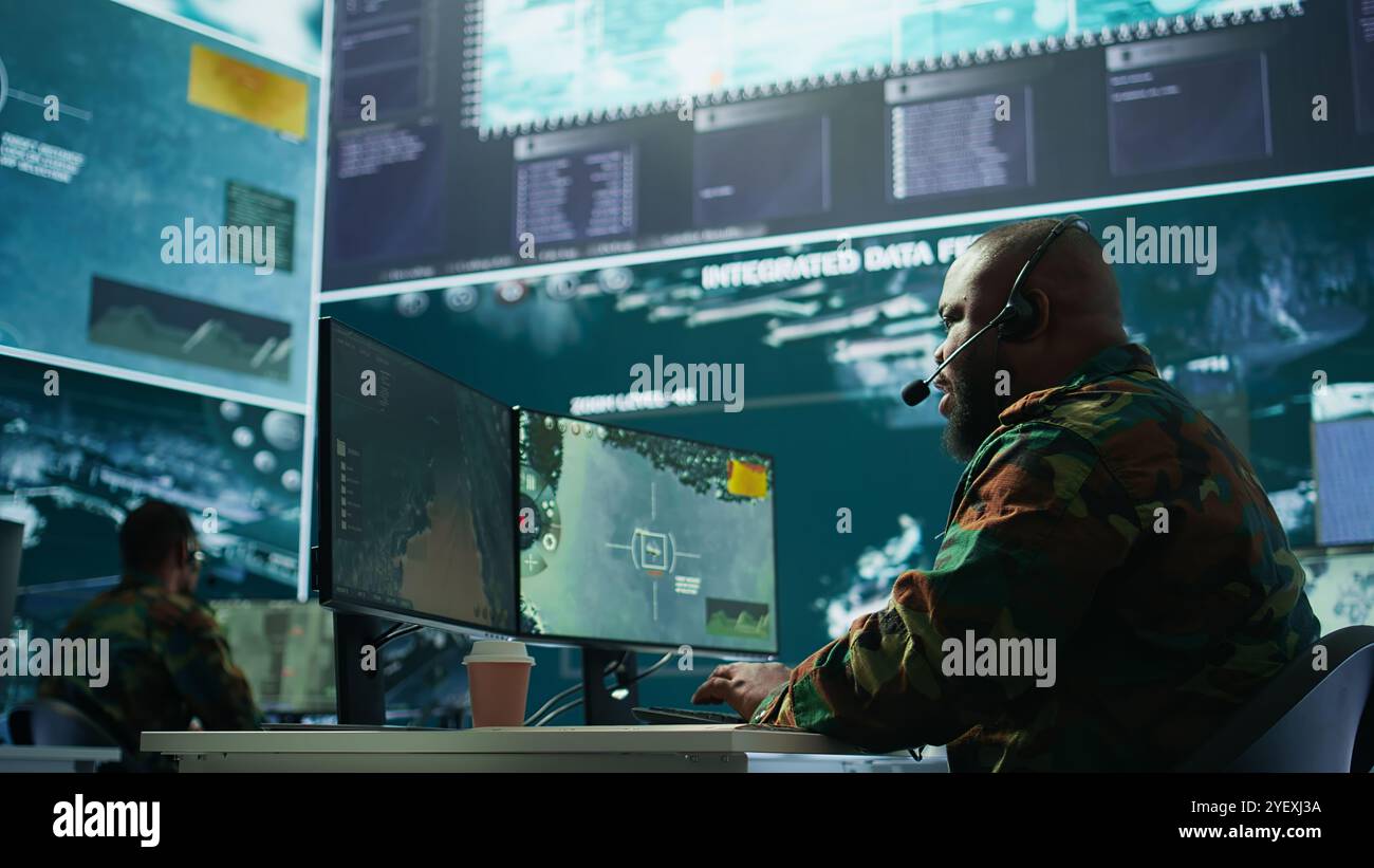 Military control room features army personnel monitoring surveillance systems, soldiers ...