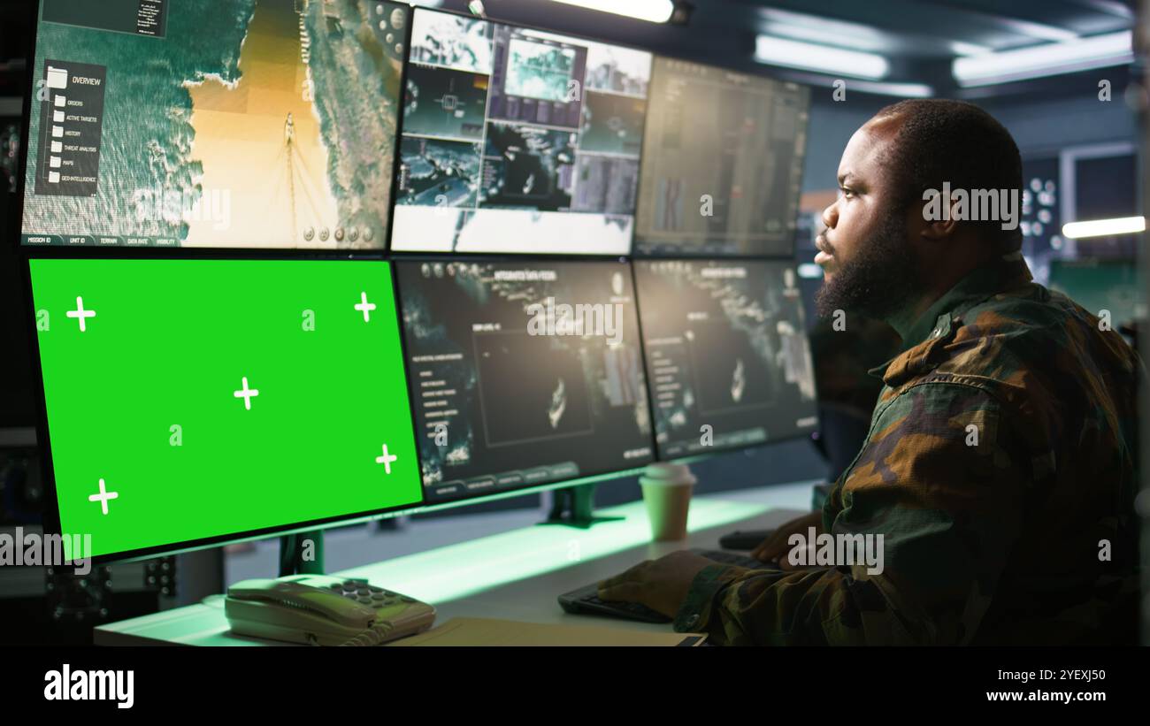 Military agent working in control room, using software on green screen ...
