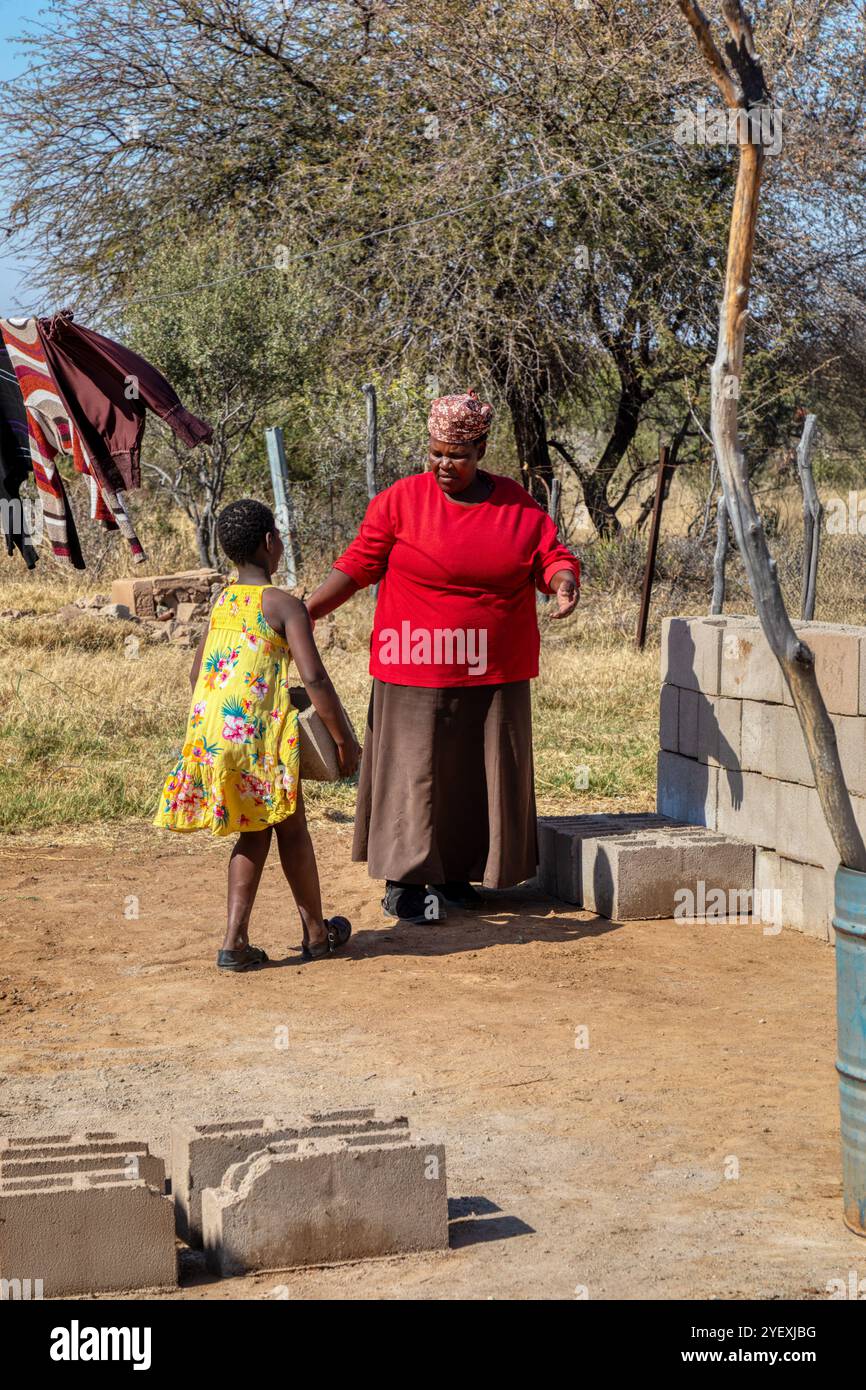 domestic life in an african village mother and daughter in the yard ...