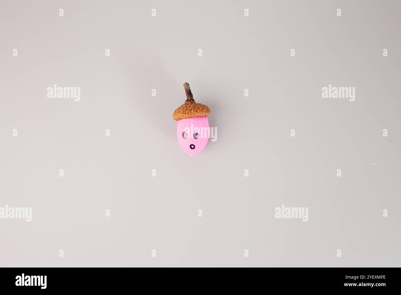 small acorn with a pink painted body and a natural brown cap. decorated ...