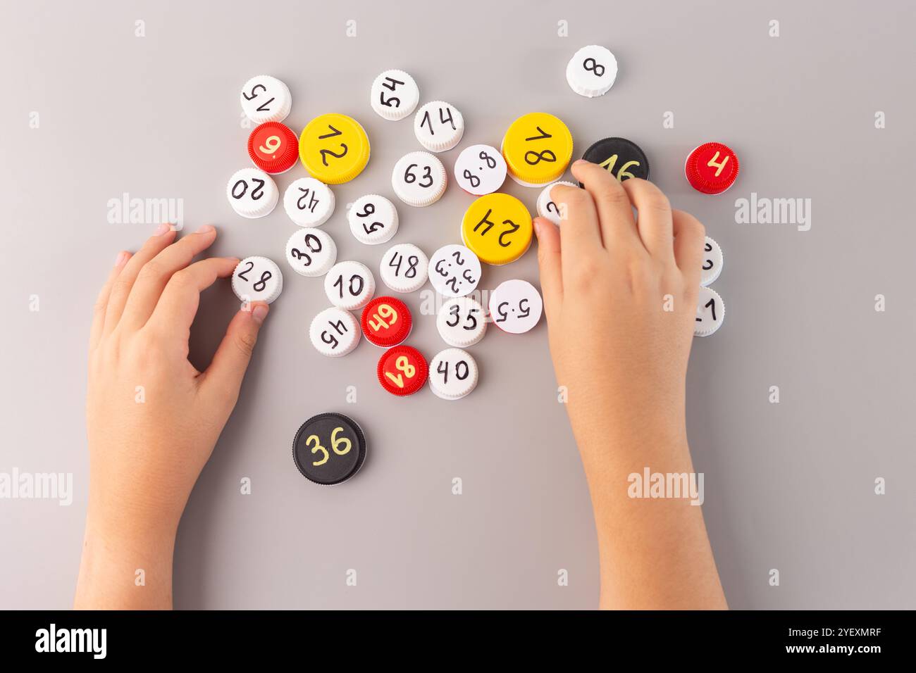 Child holding white cap with math problems, on gray background ...