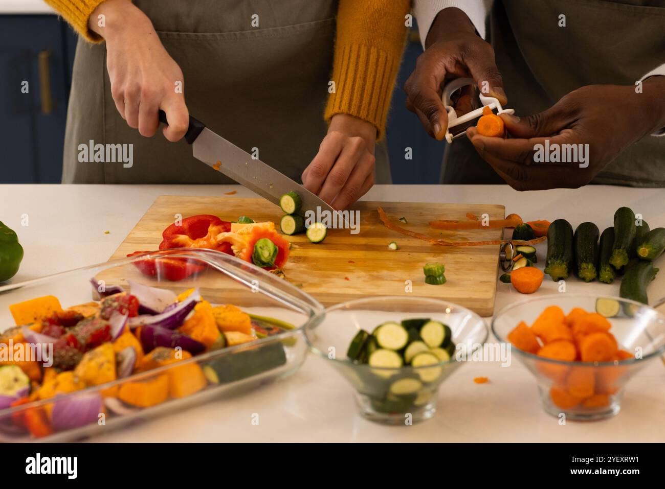 Christmas time, multiracial couple preparing fresh vegetables together ...