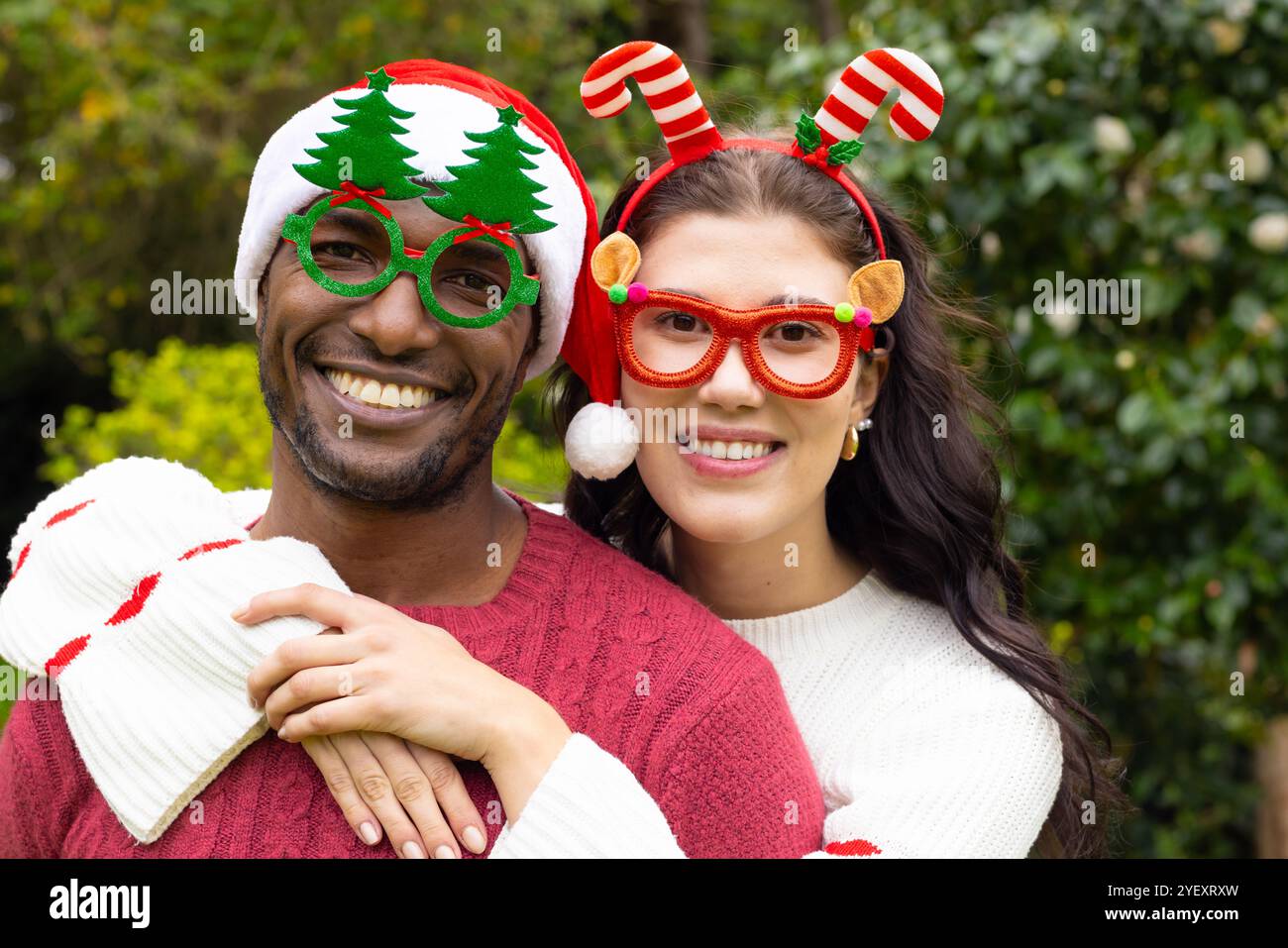 Celebrating Christmas outdoors, multiracial couple wearing festive ...