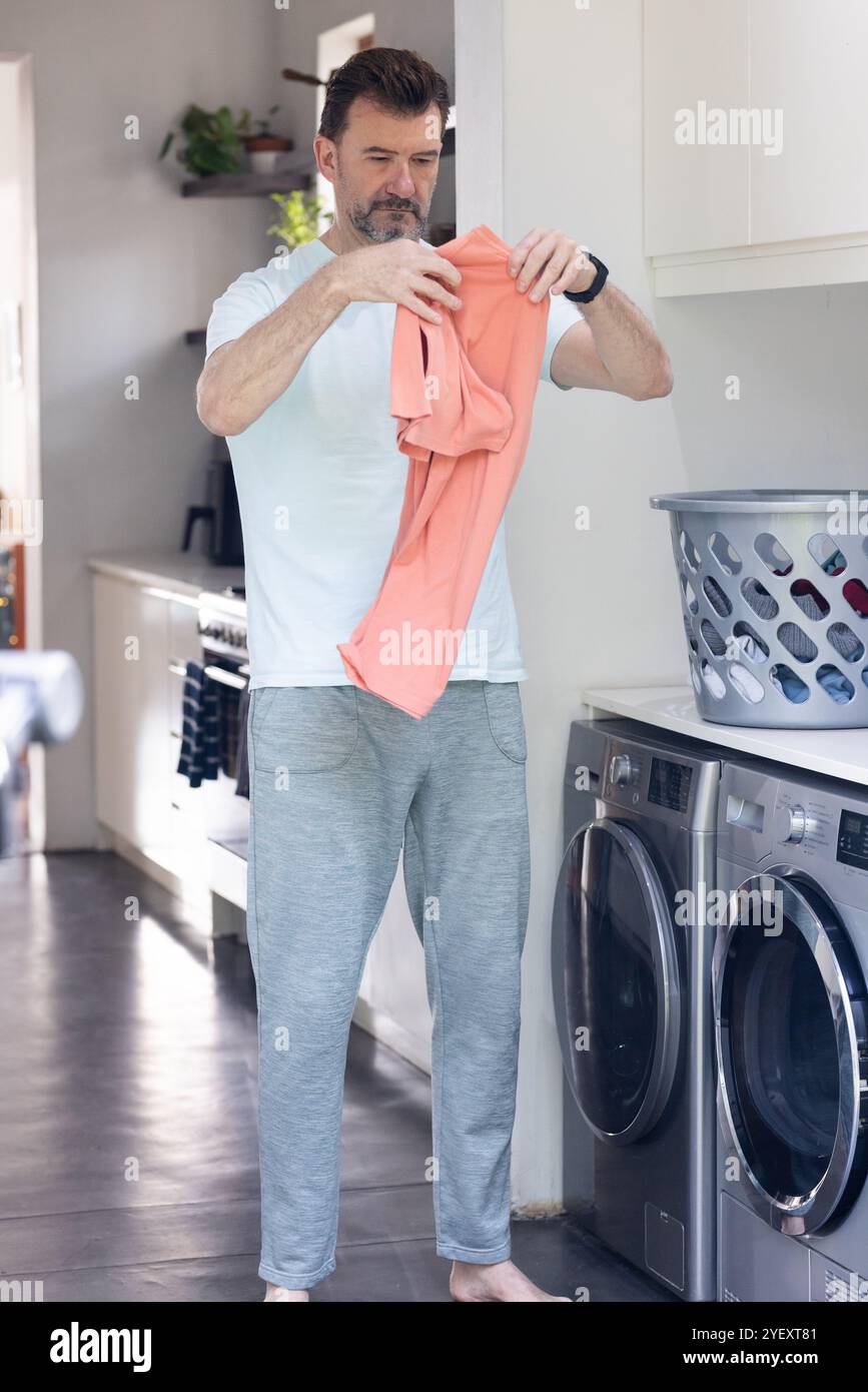 senior man folding laundry at home, focusing on household chores Stock ...