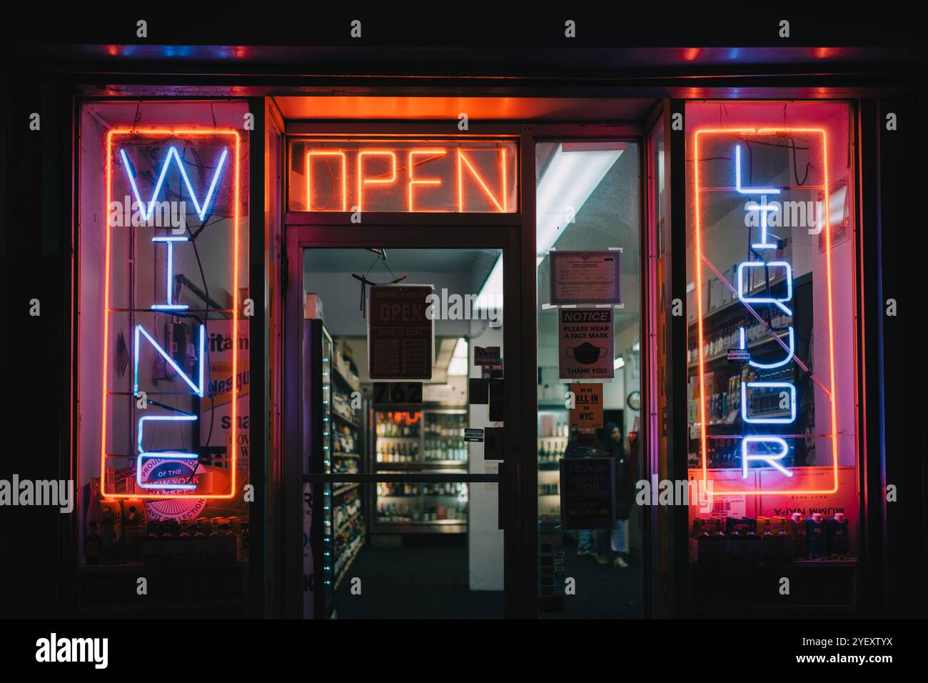 Neon signs for wine and liquor illuminate a storefront in Midtown ...
