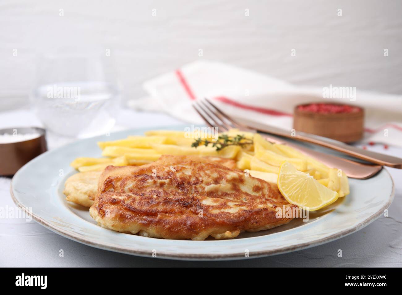 Tasty soda water battered fish, potato chips and lemon slice served on ...