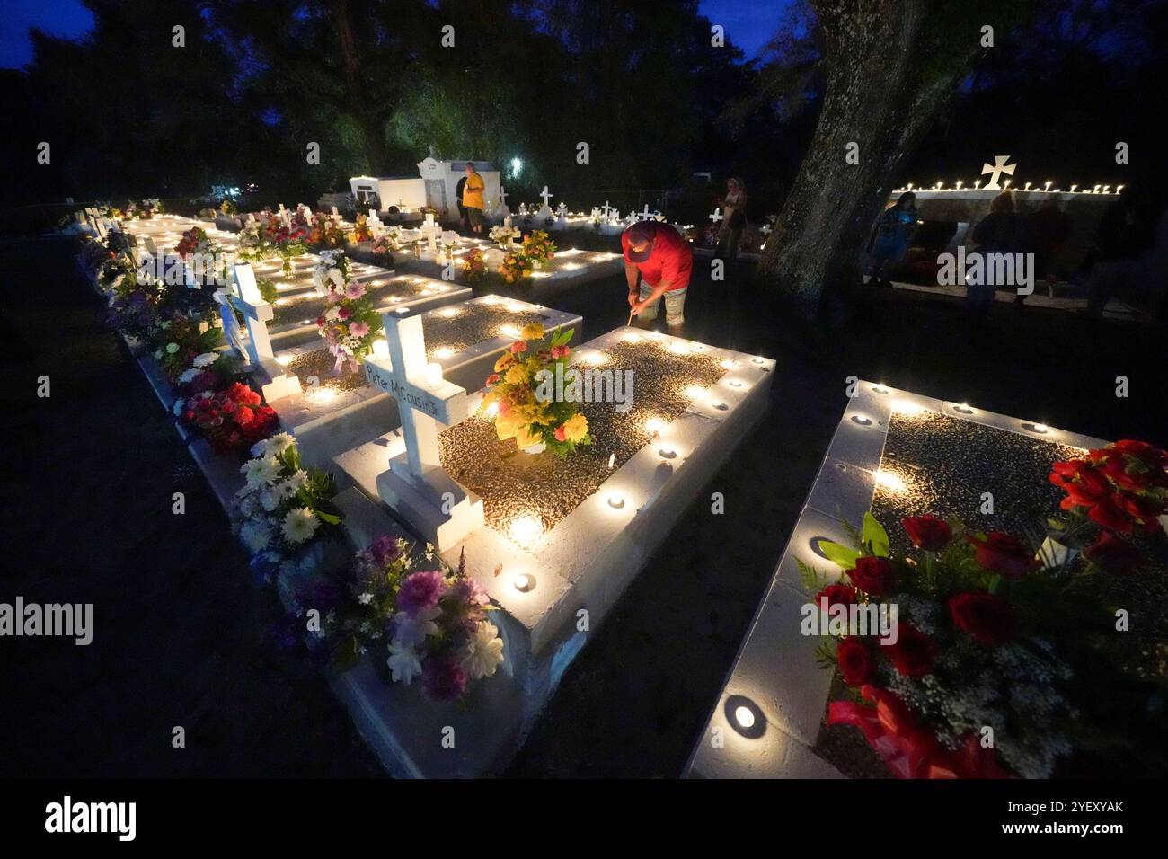 Randy Raymond lights candles on his family graves for All Saints Day ...
