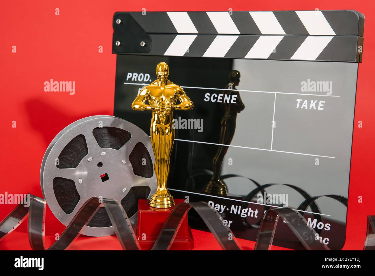 Golden trophy in shape of human figure, movie clapper and film reel on ...