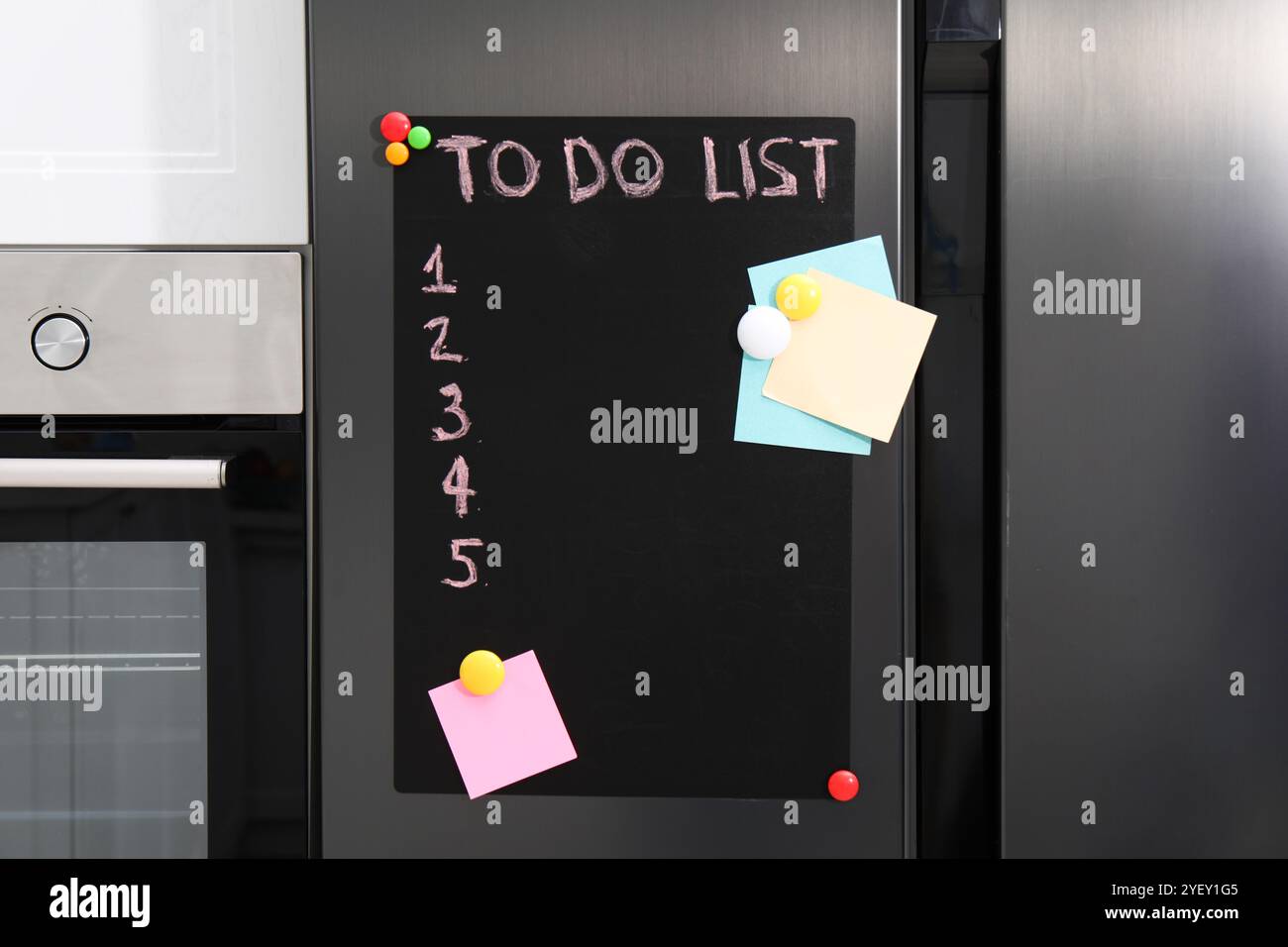 Magnetic board with to do list and notes on refrigerator in kitchen ...