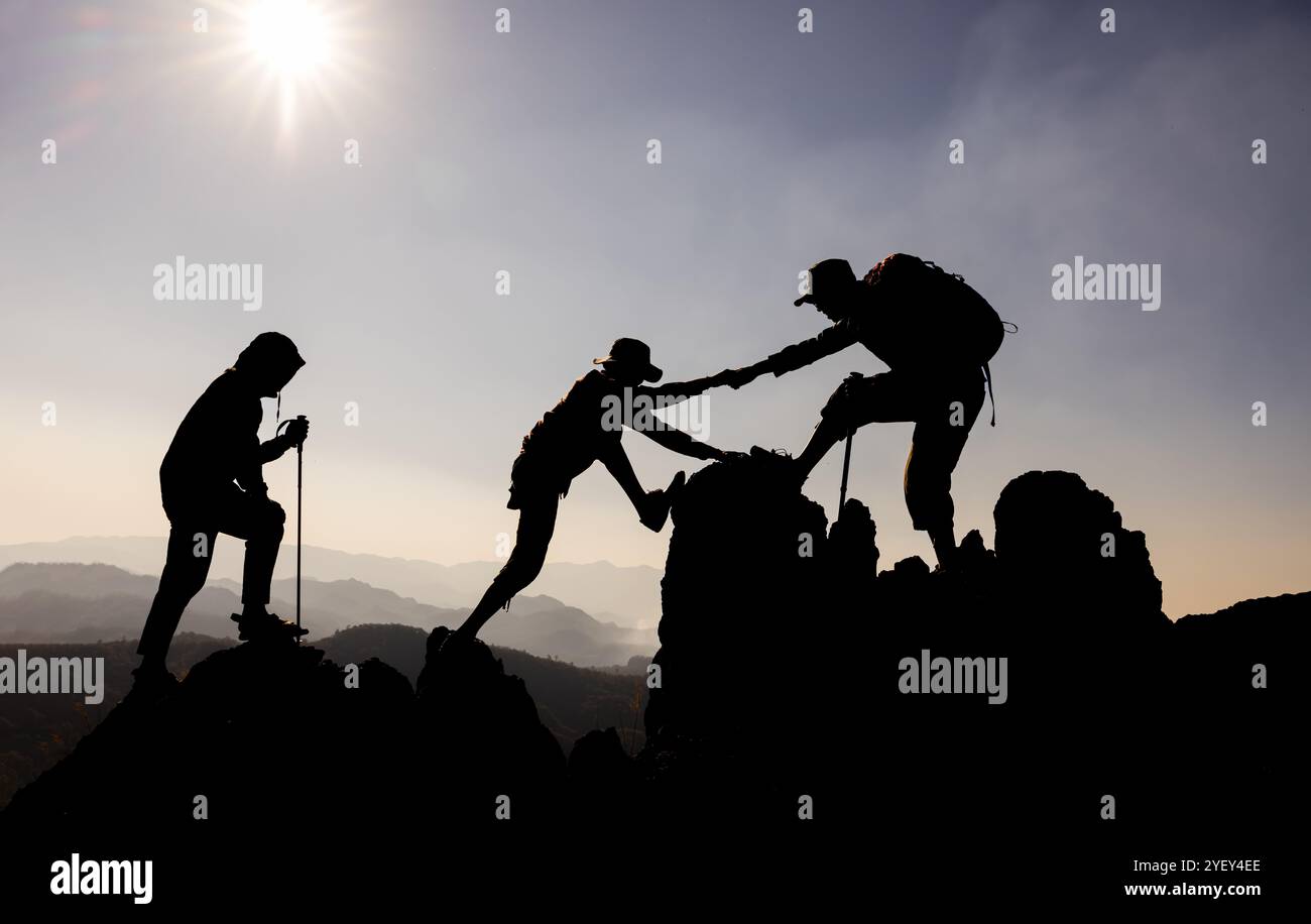 Silhouette of a team of climbers ascending a rugged mountain, Group of ...