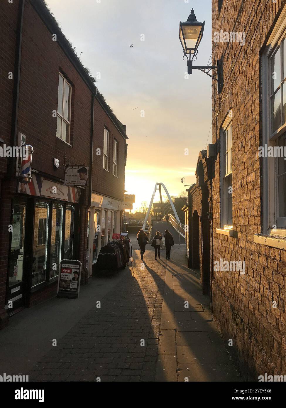 people walking towards St. Botolph's bridge forming long shadows in ...