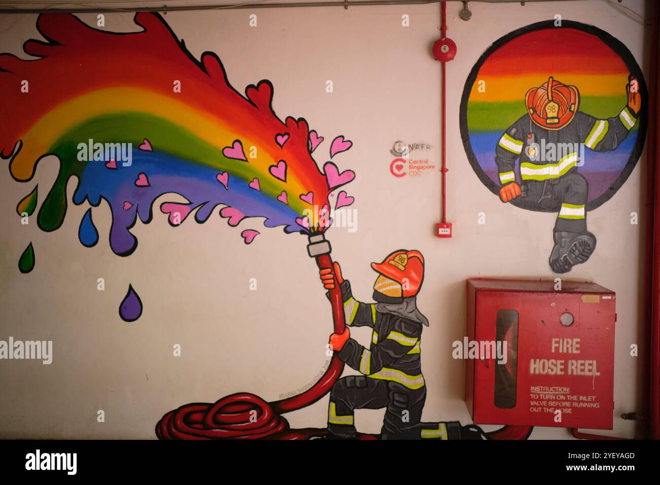 wall with red fire hose box and firefighter artwork Stock Photo - Alamy