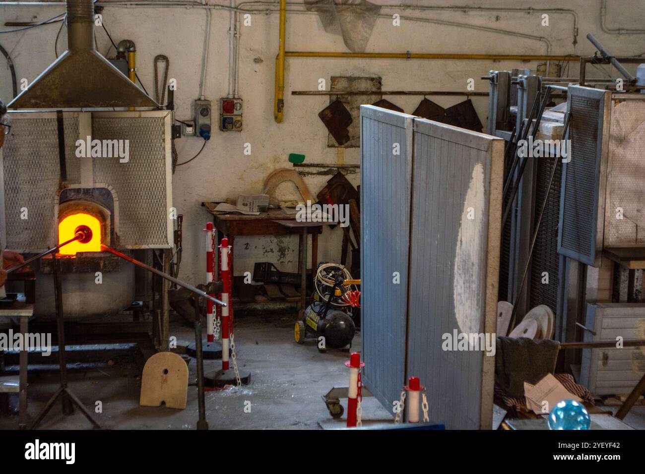 Murano glass-blowing factory. blower forming beautiful piece of glass ...